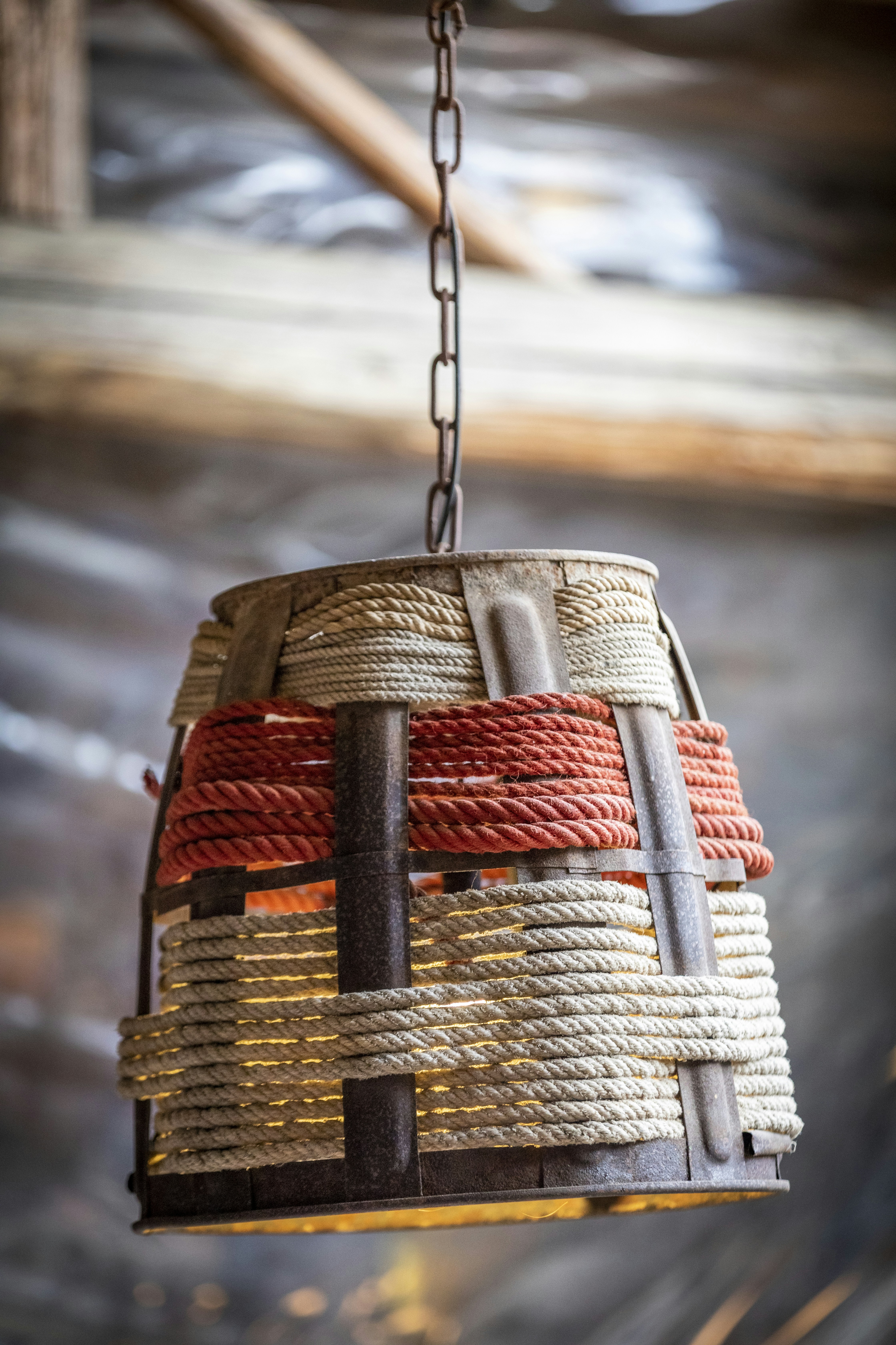 Amber Glow: Rope-Wrapped Lantern Suspended in a Weathered Workshop