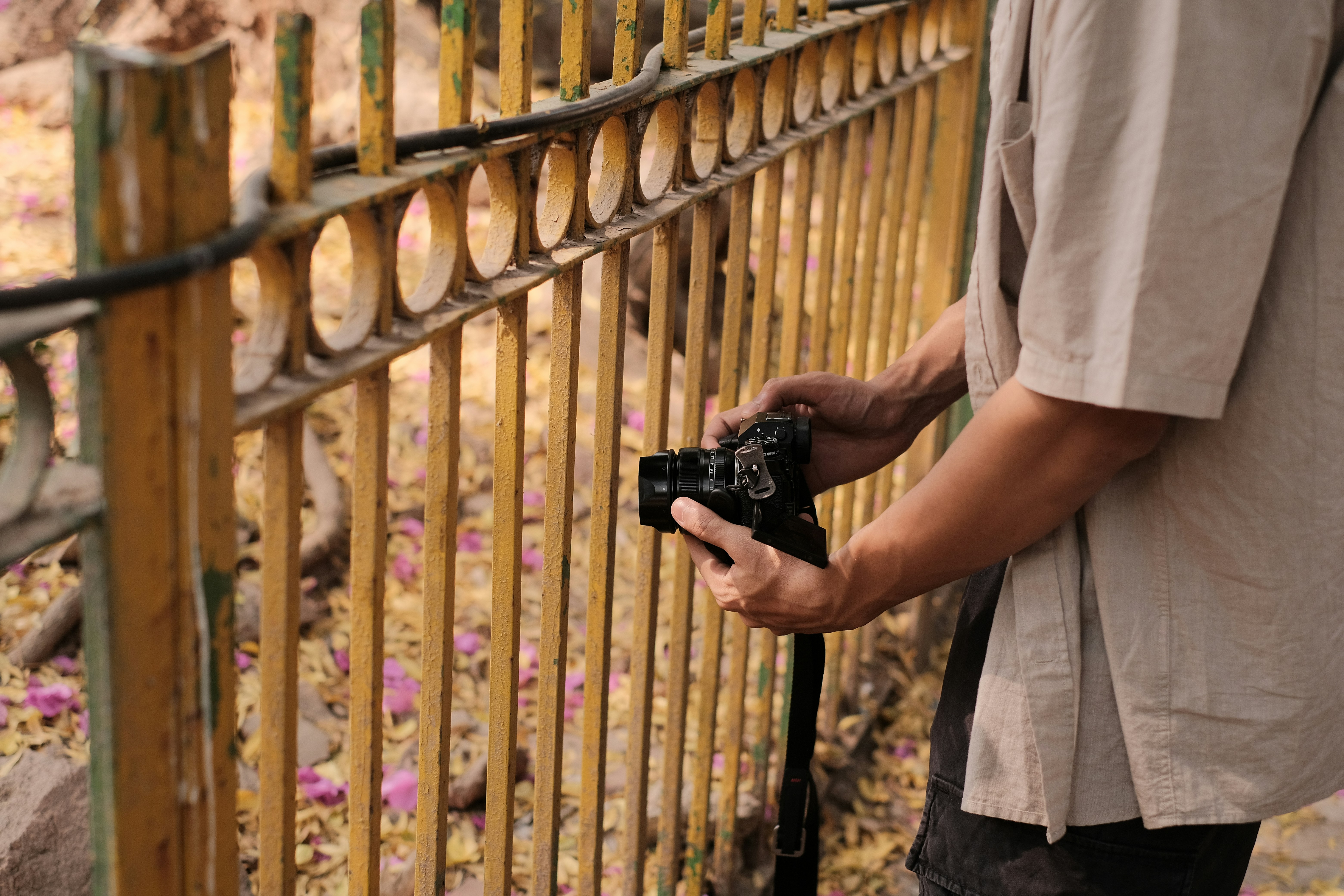 Hands in Frame: A Quiet Moment Framed by a Railed Fence