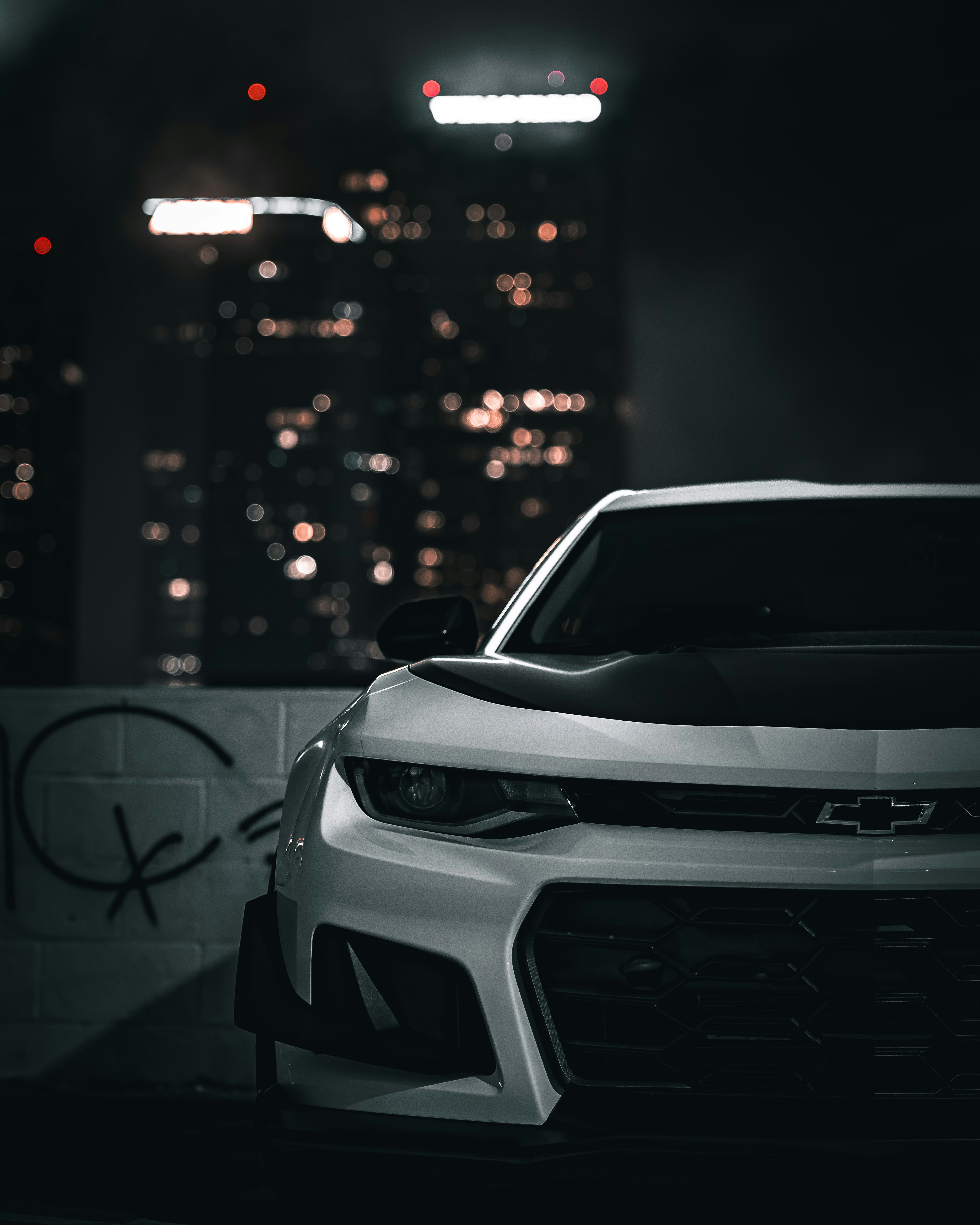 Une voiture blanche garée devant une ville la nuit photo – Photo Centre ...