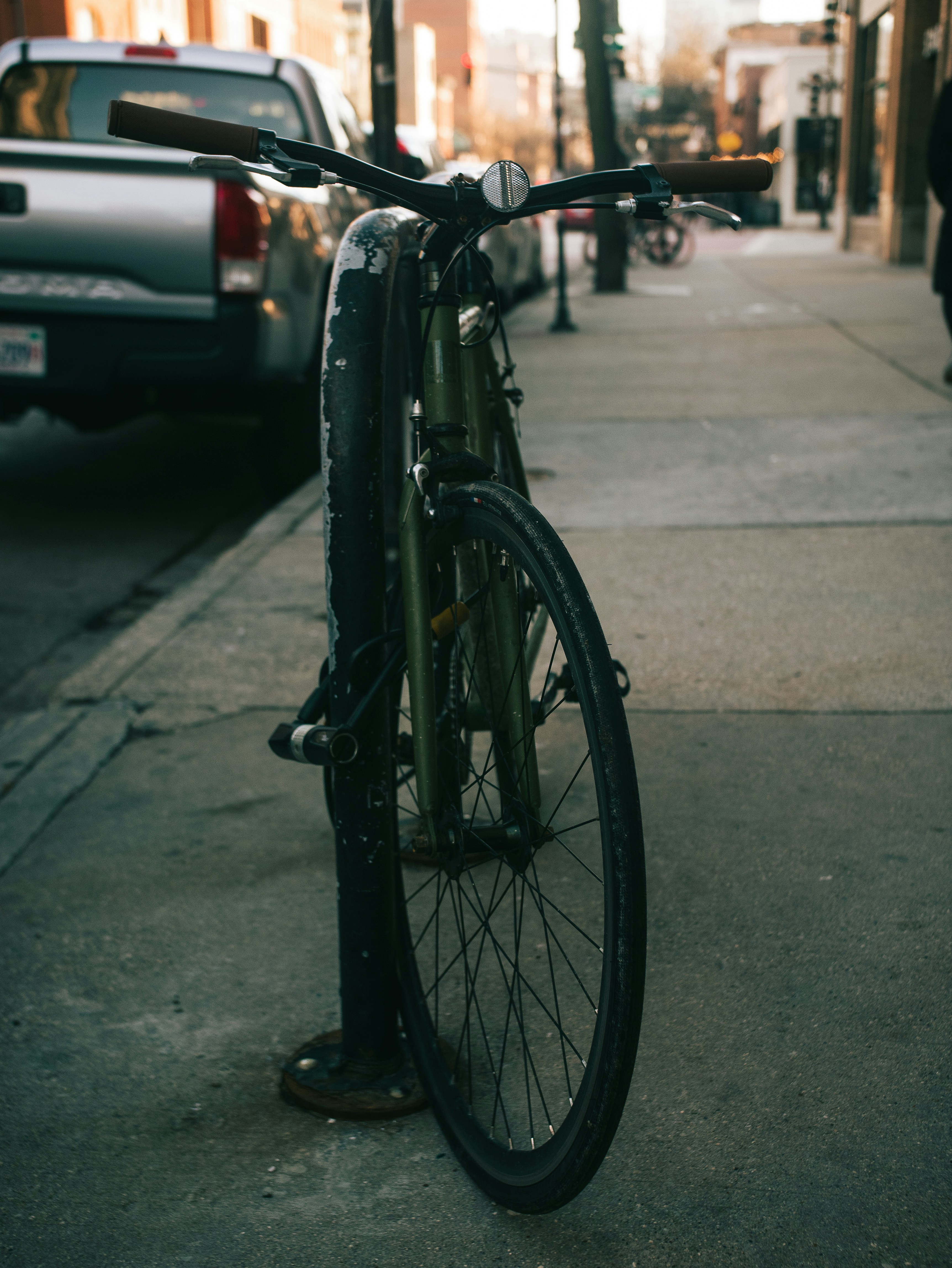 A bicycle chained to a pole on a city street photo – Free Usa Image on ...