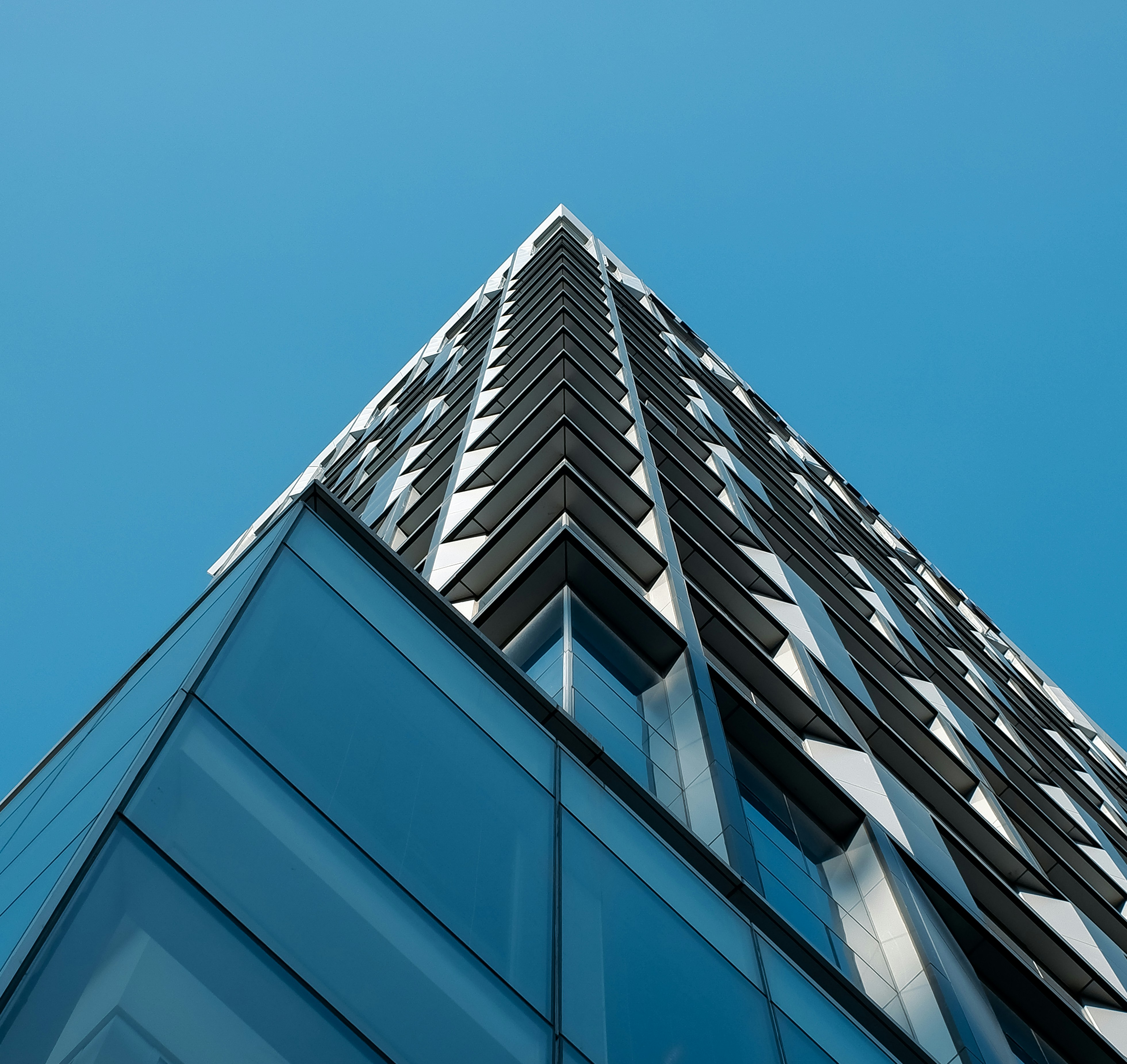 Modern skyscraper photographed from a low angle against a clear blue sky.