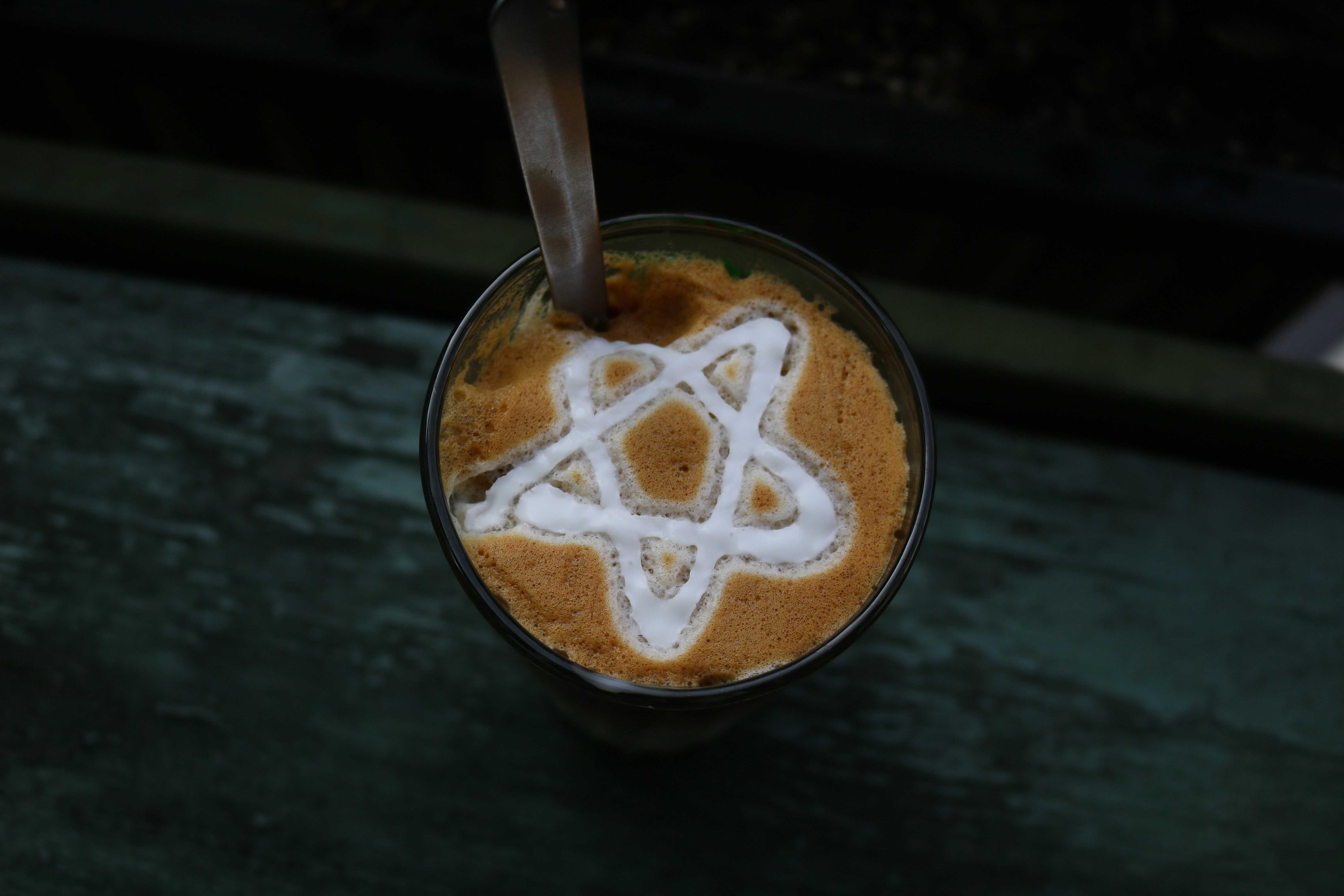 Atomic Latte: Crema Orbits on a Dark Green Wooden Table