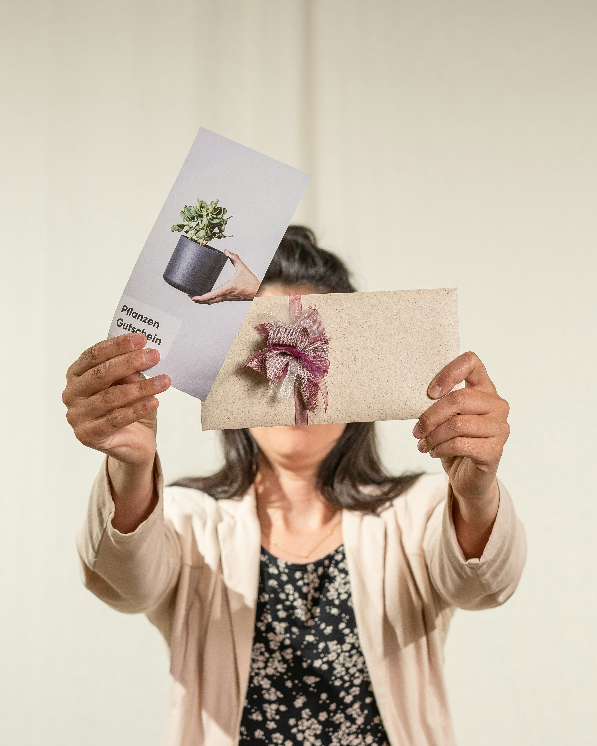 Gifting in Focus: Hands Raise Two Gift Cards toward the Viewer