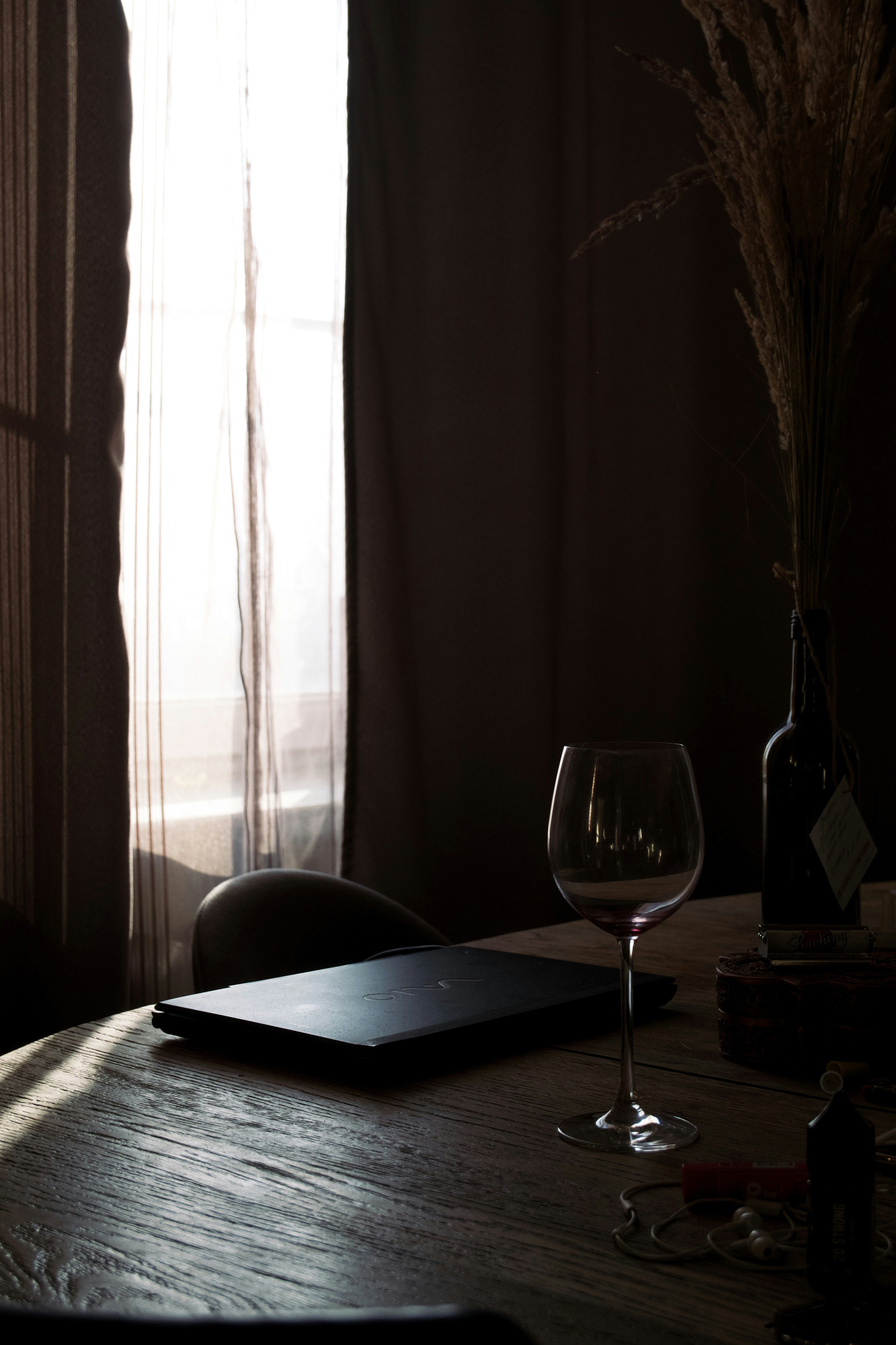Backlit Still Life: Wine Glass and Quiet Hardware on a Wooden Table