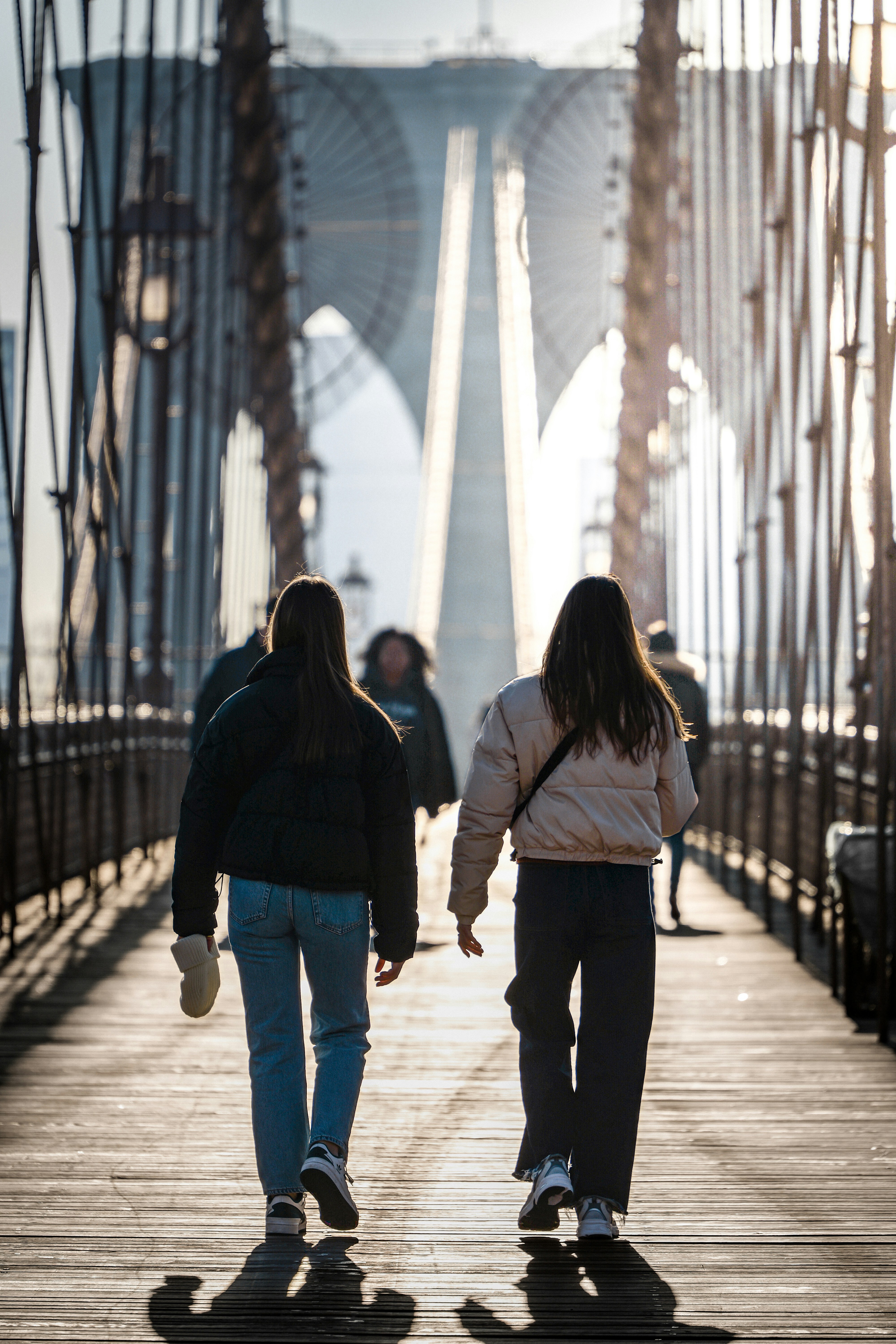 A couple of people walking across a bridge photo – Free Brooklyn bridge ...