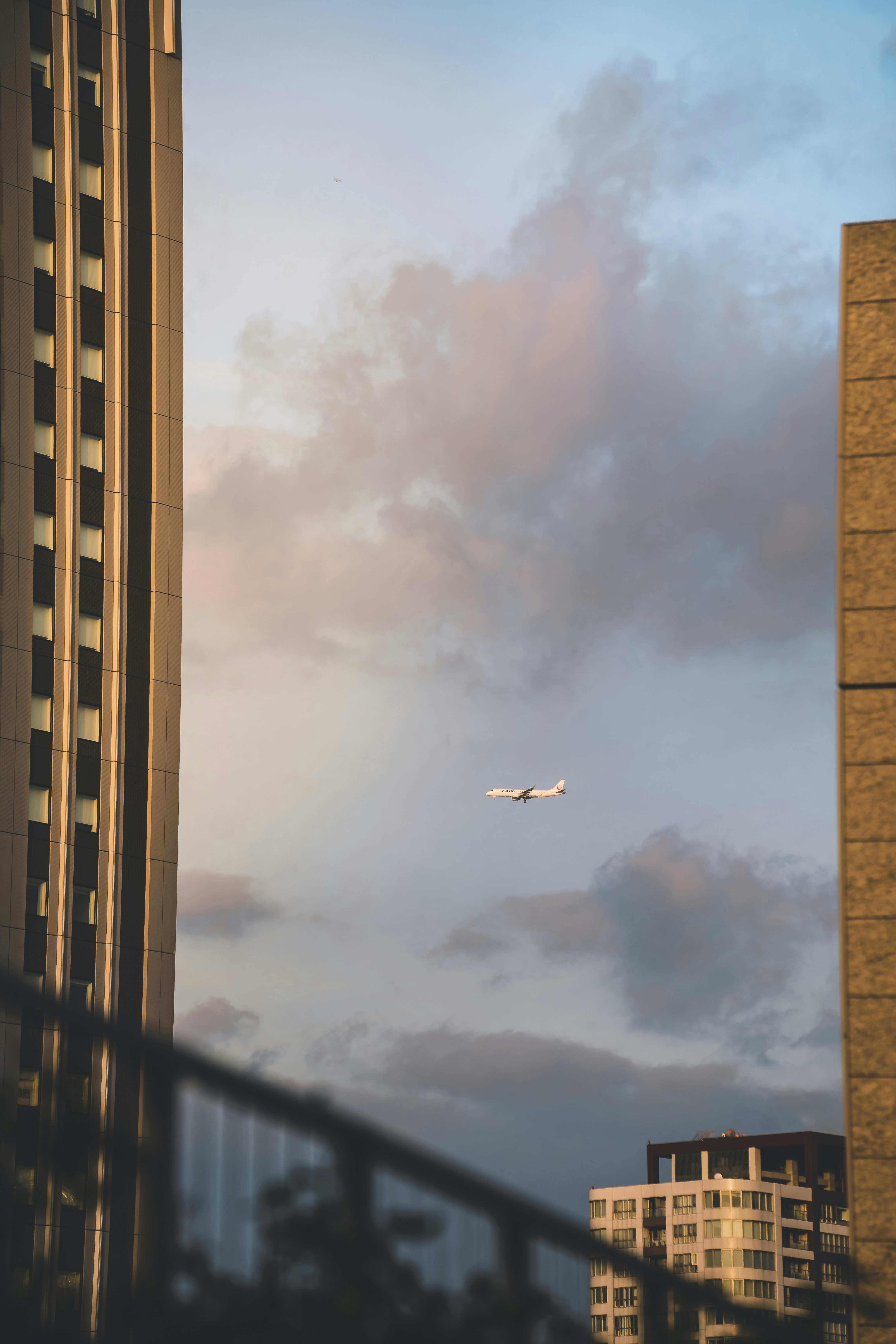 Jet Between Towers at Golden Hour: A Skyline's Quiet Passage