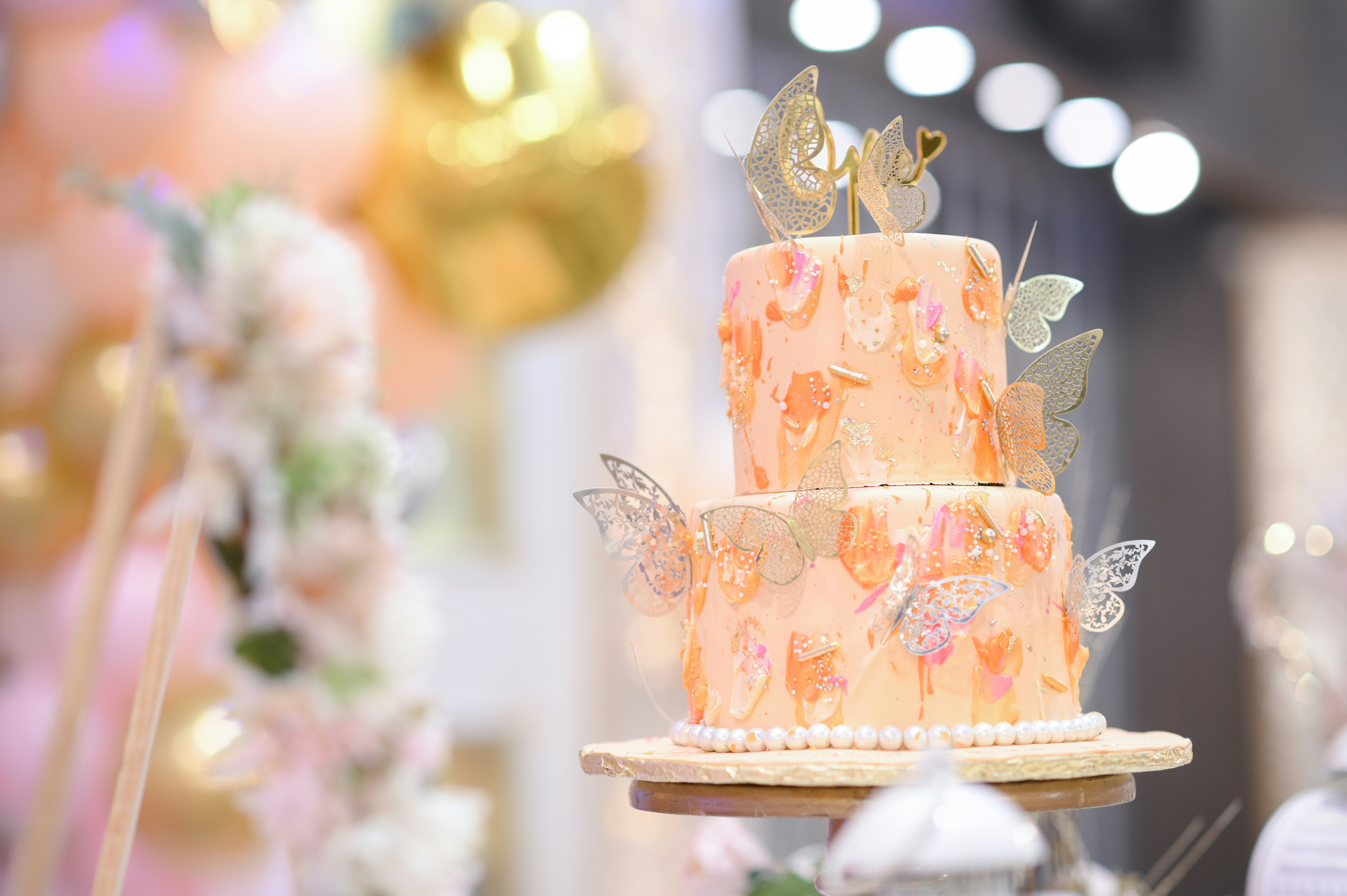 A three tiered cake with butterflies on top of it photo – Free People ...