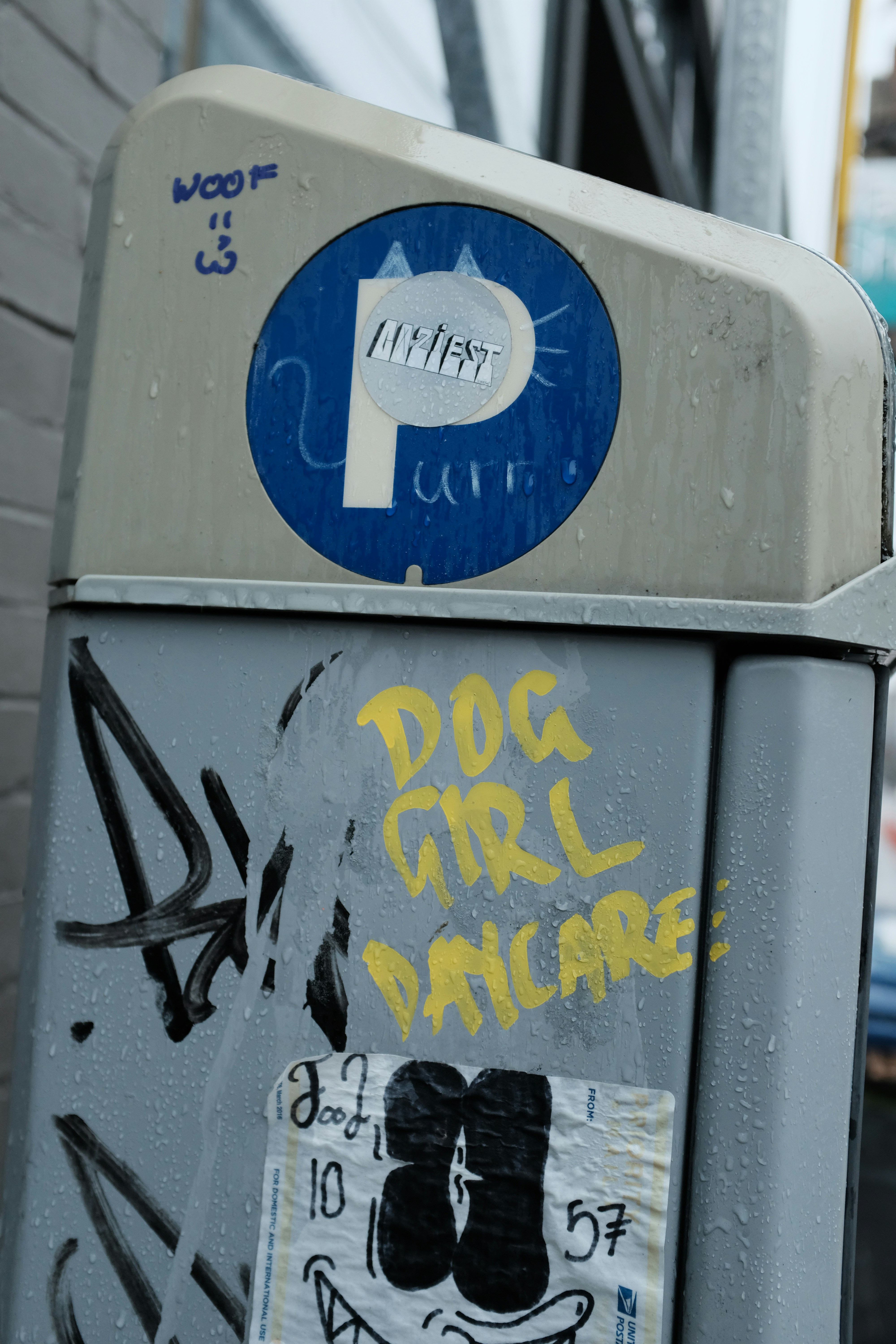 a parking meter covered in graffiti next to a building