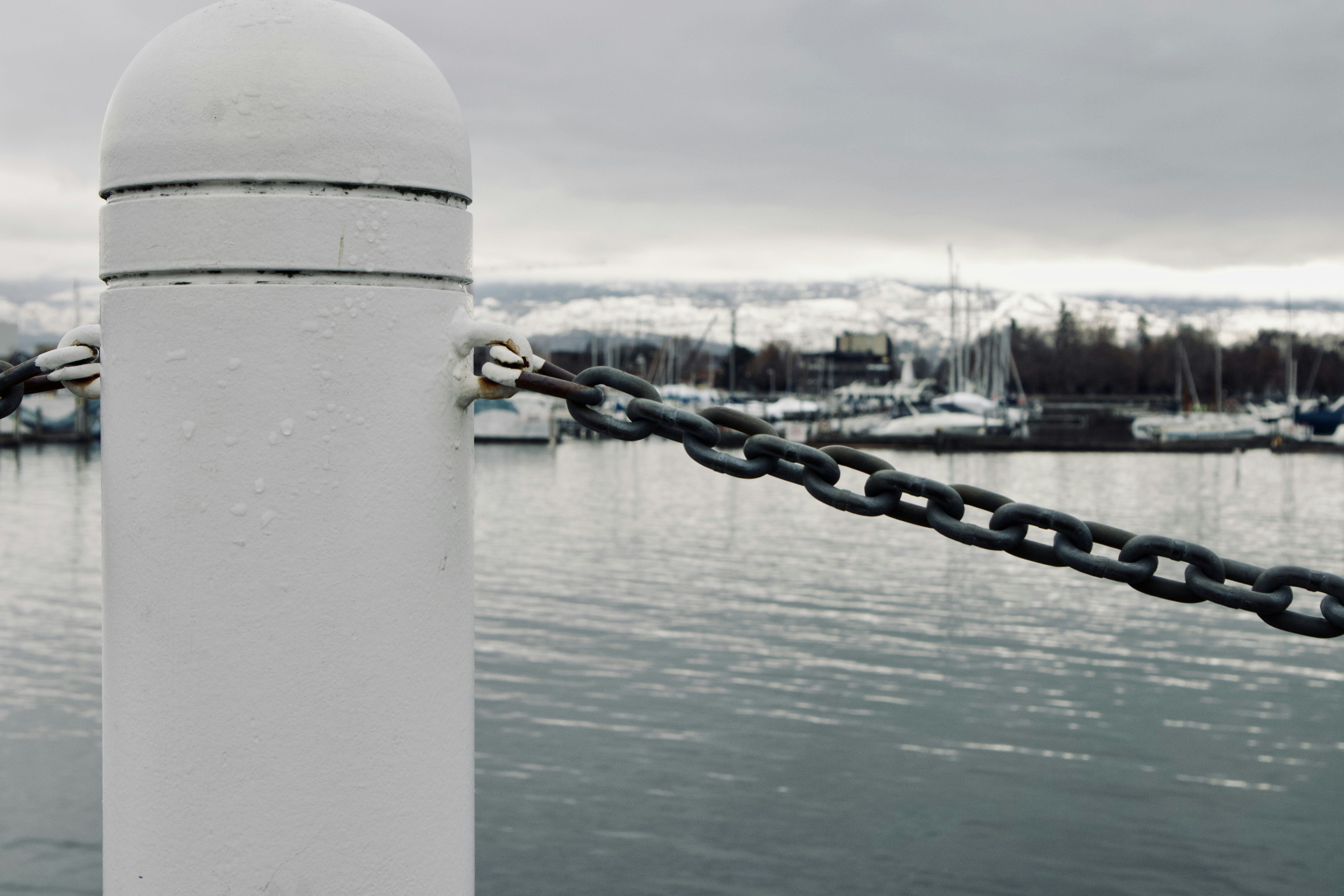 Marina Bollard in Focus: Chain Lines Linking Sky and Sea