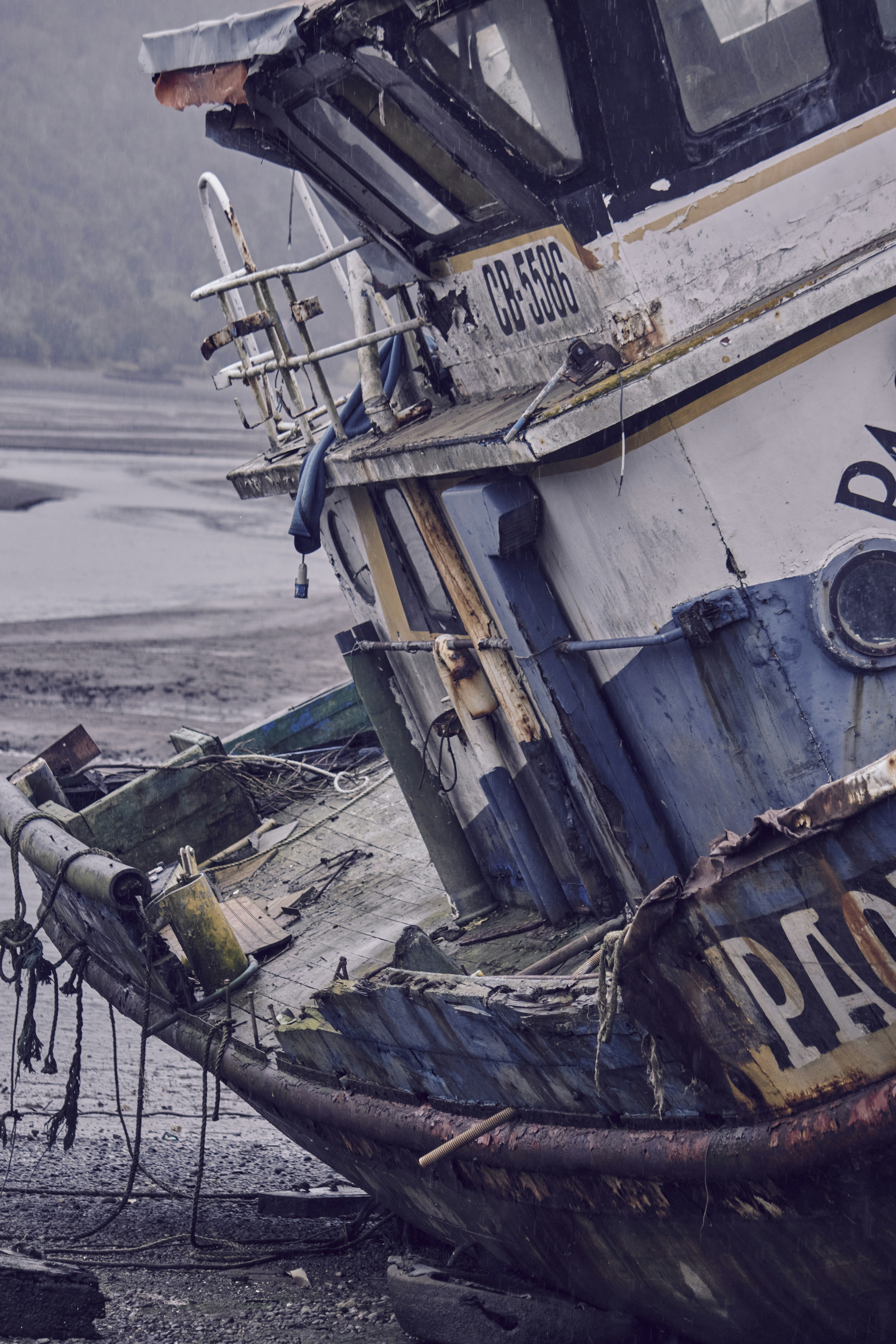 Leaning Hull at Dusk: a Weathered Vessel Resting on Mudflats