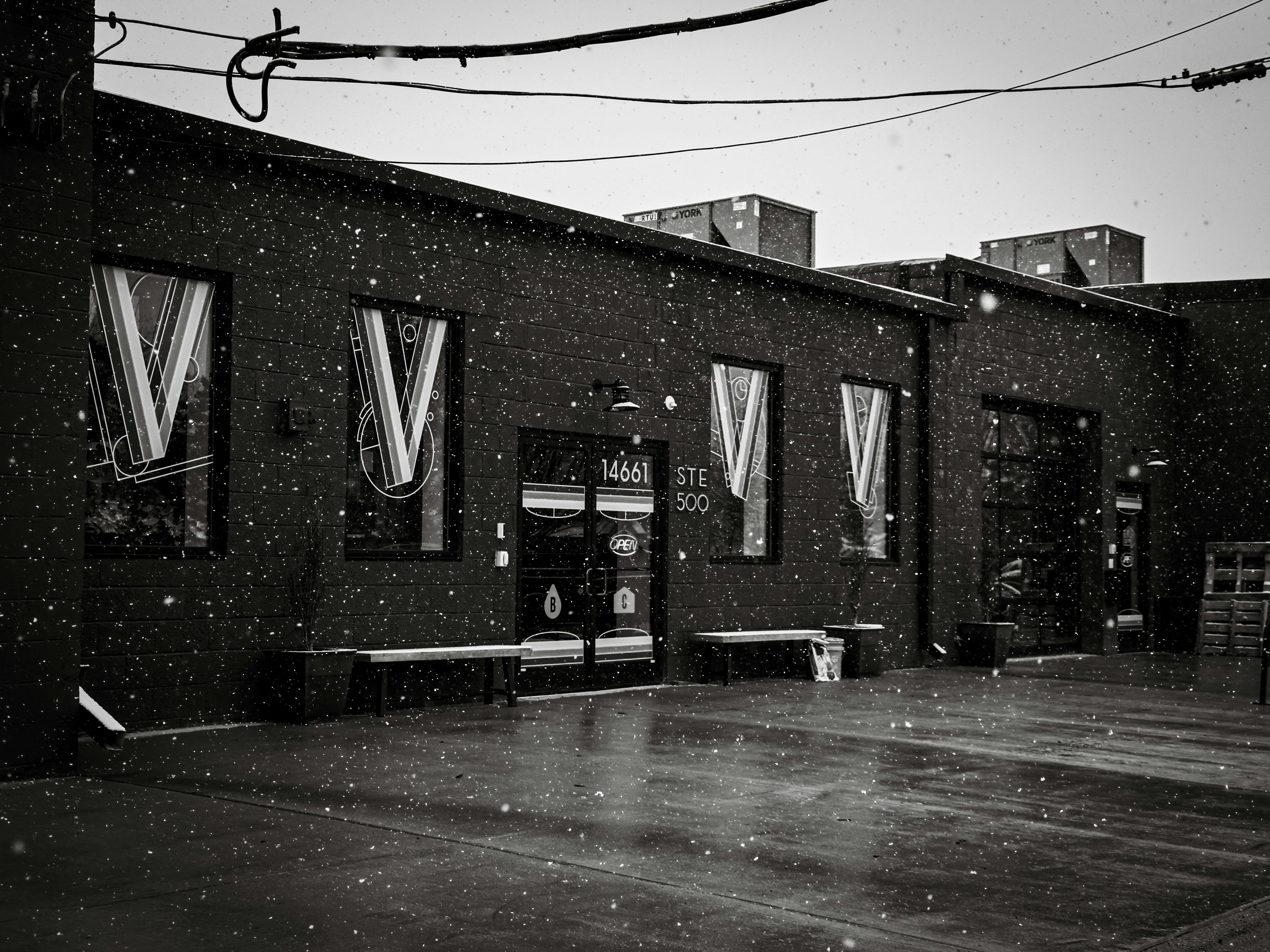 Snowfall on a Brick Storefront: Geometric Windows Framing a Central Door
