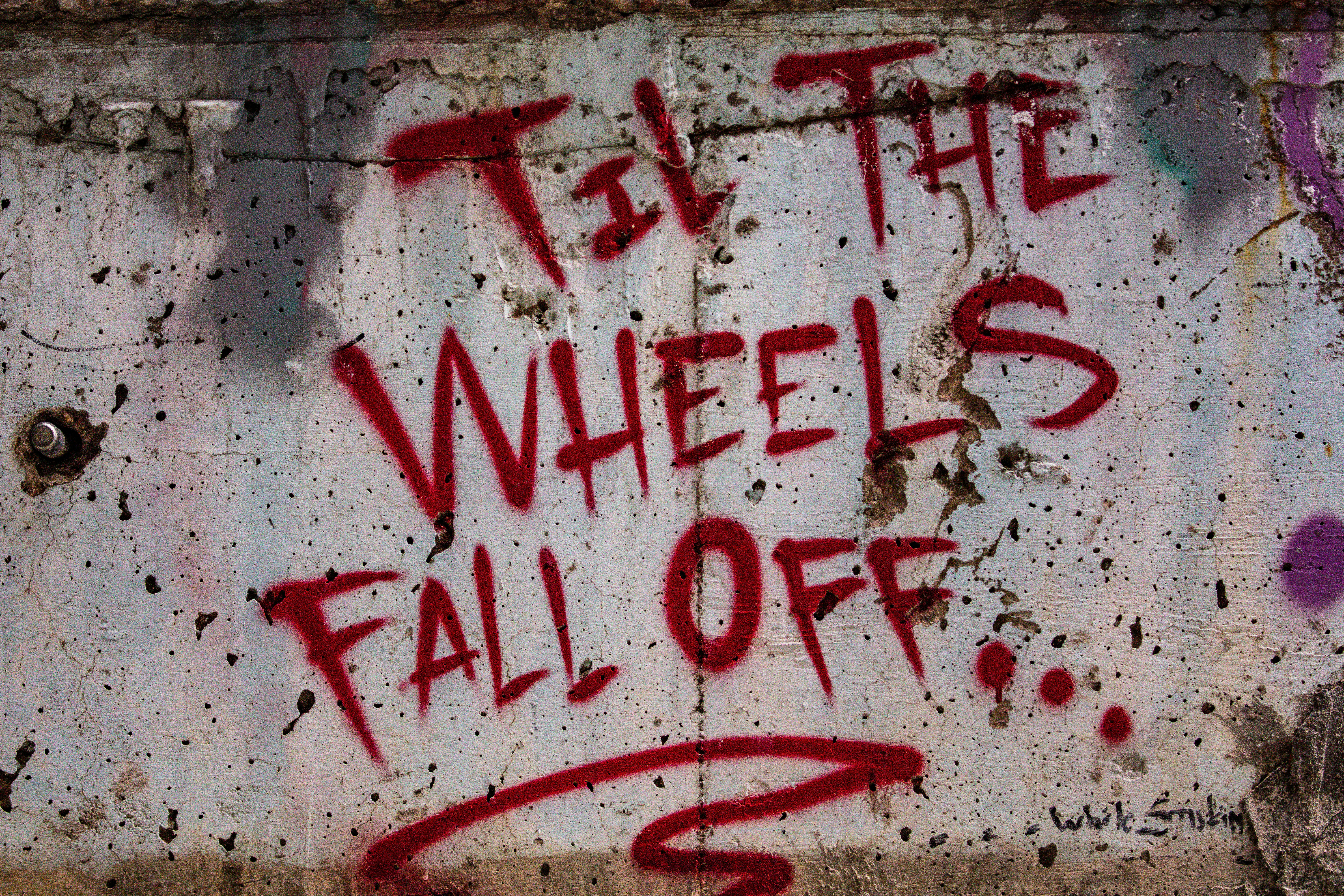 Till the Wheels Fall Off: Red Graffiti on a Weathered Wall