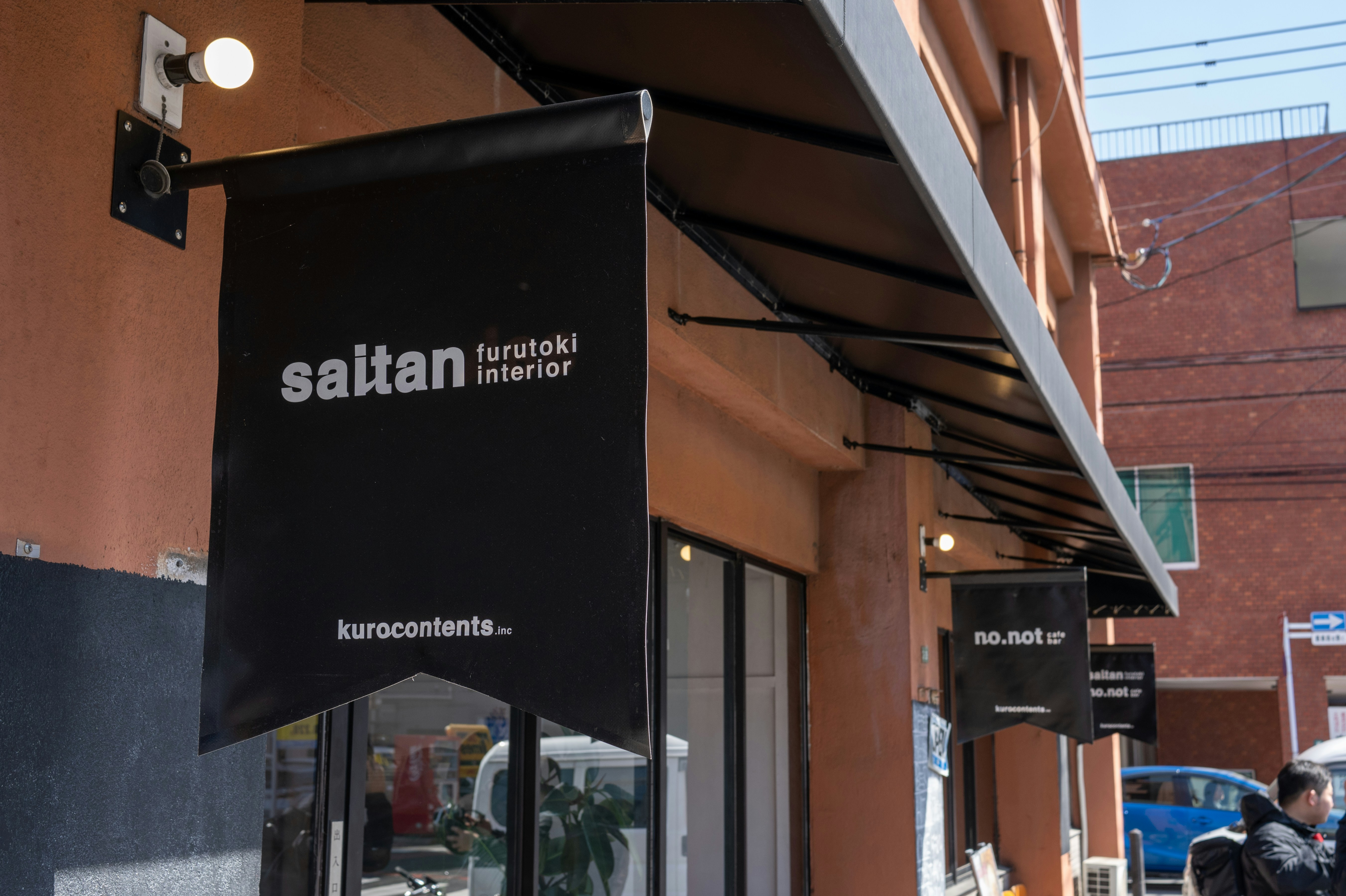 a black sign hanging from the side of a building