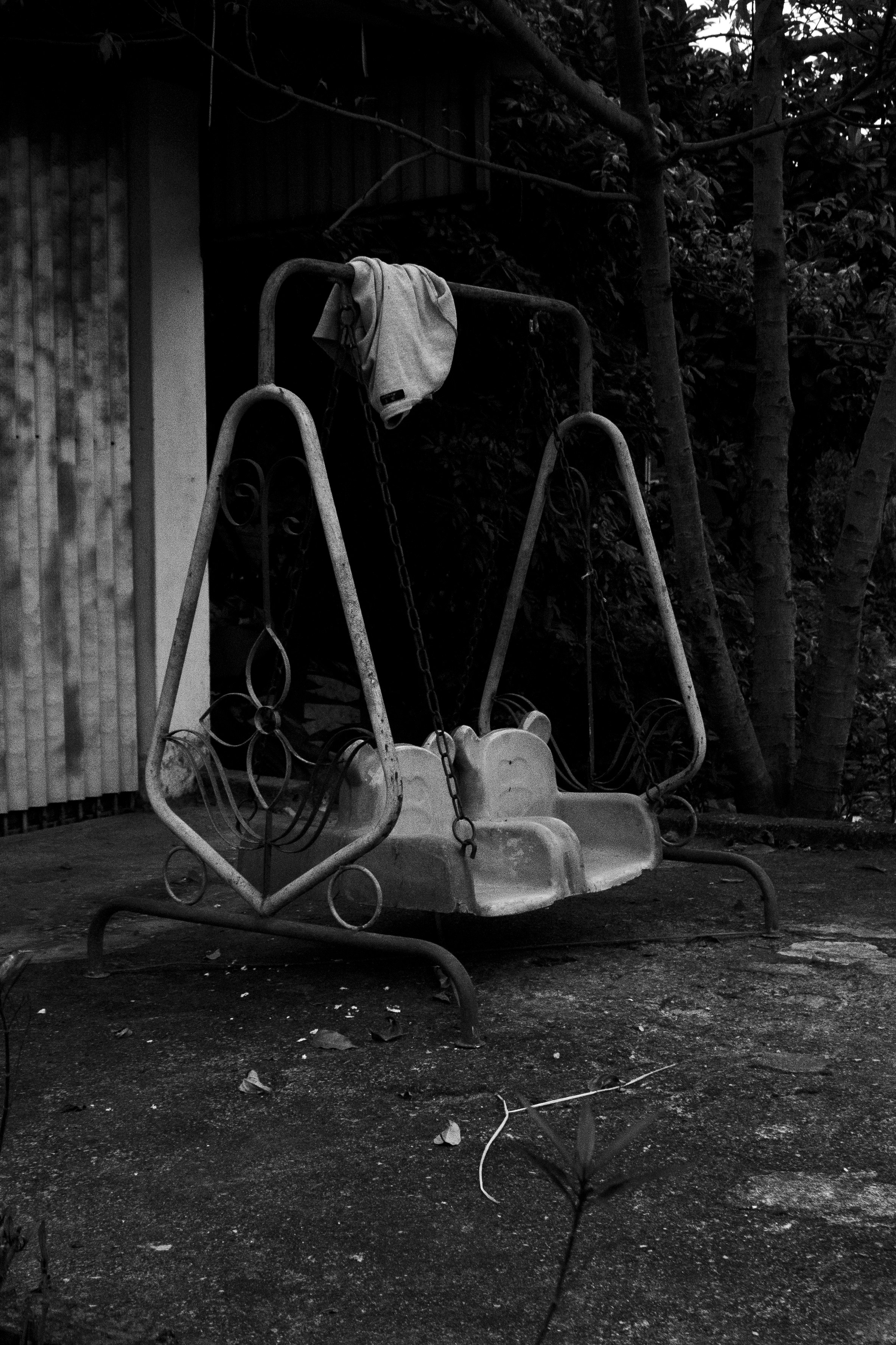 Un columpio roto sentado en medio de un patio foto – Imagen de Zona de ...