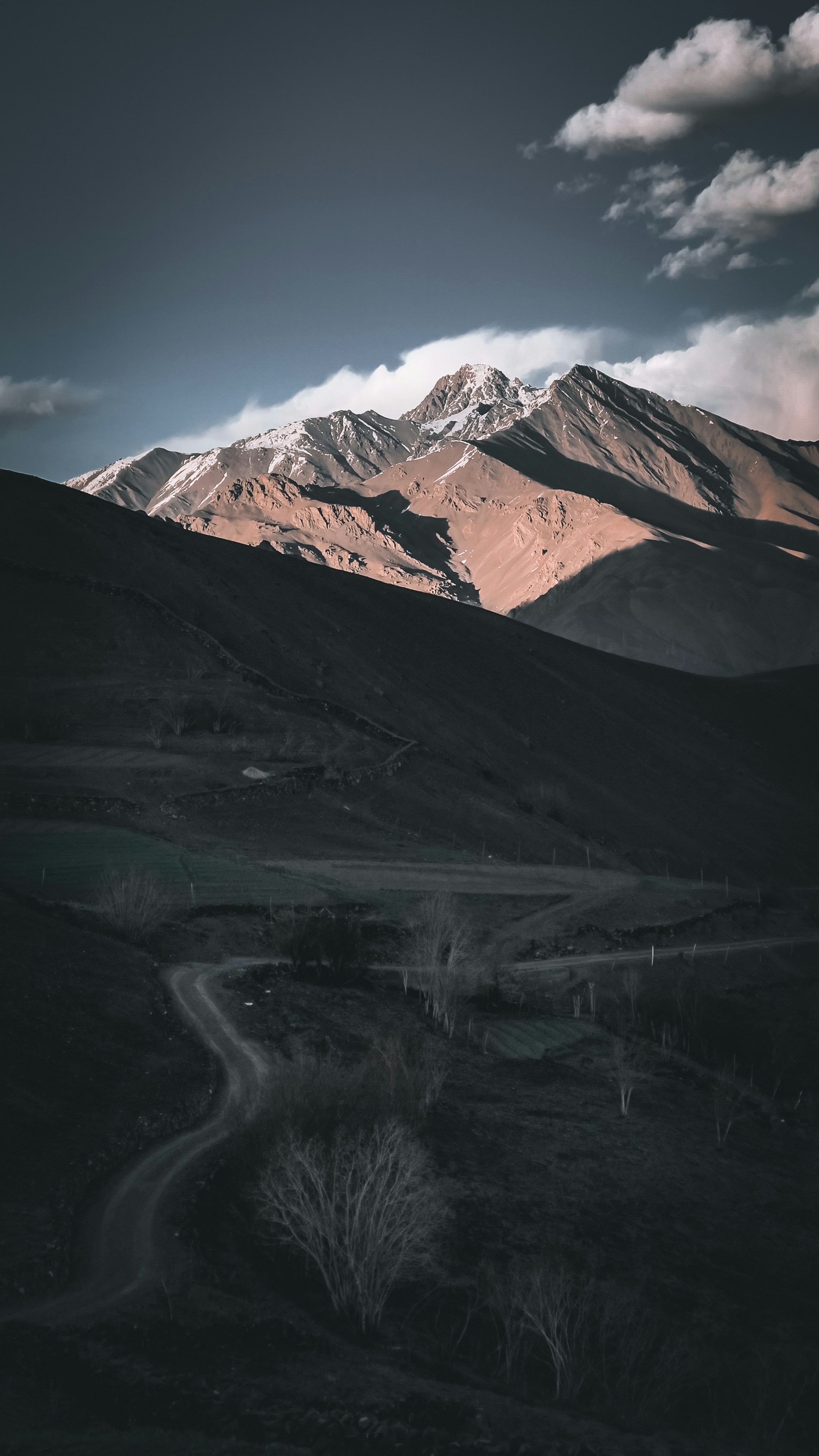 A mountain range with a dirt road in the foreground photo – Free ...
