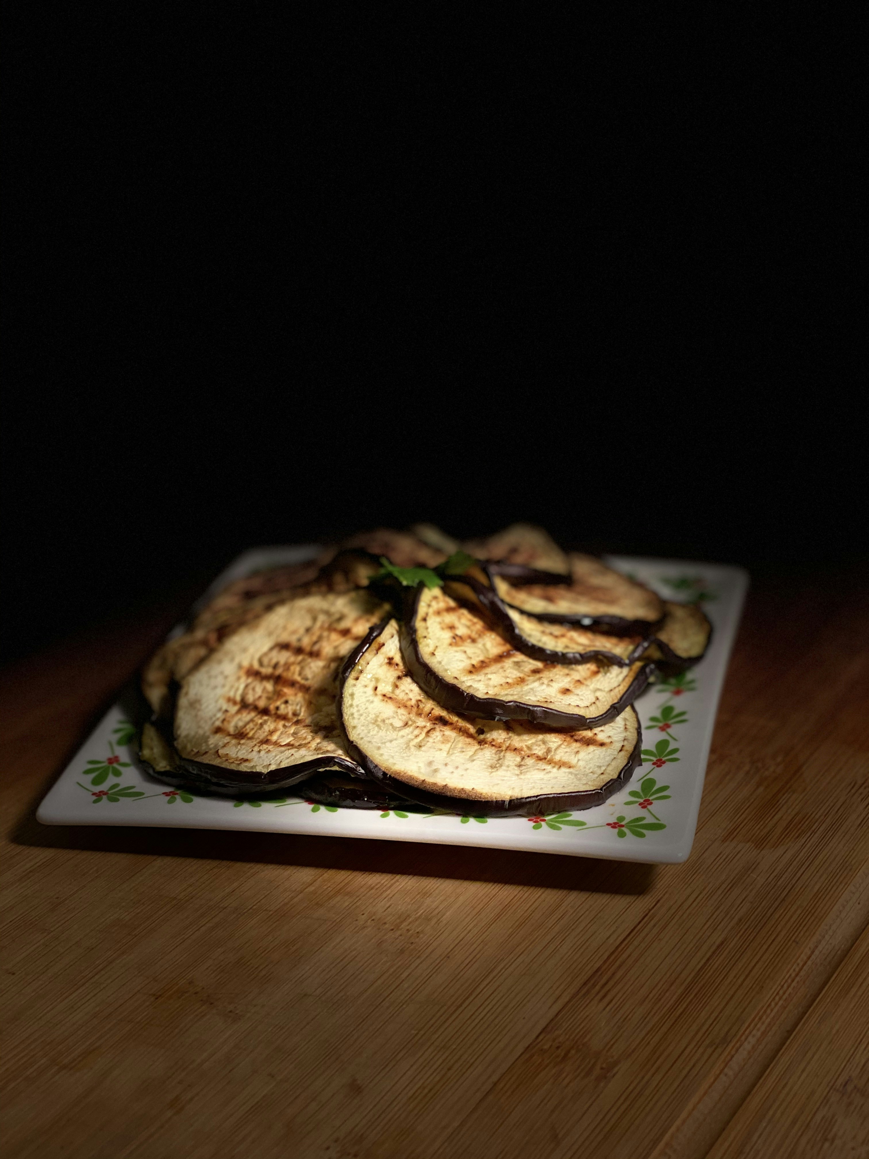 Underlit Eggplant Ensemble on a Floral Plate