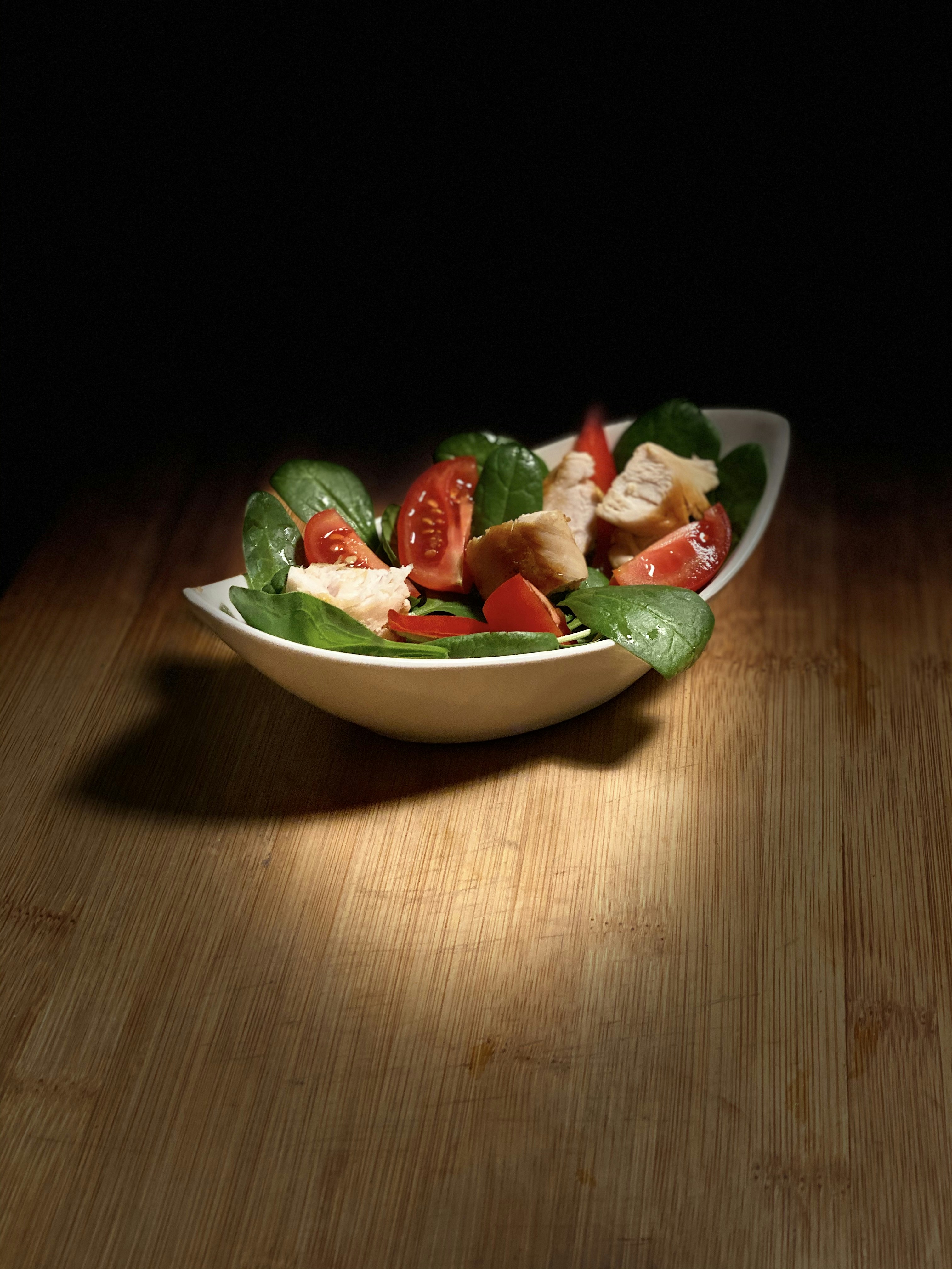 Spotlit Spinach and Chicken Salad on a Wooden Stage