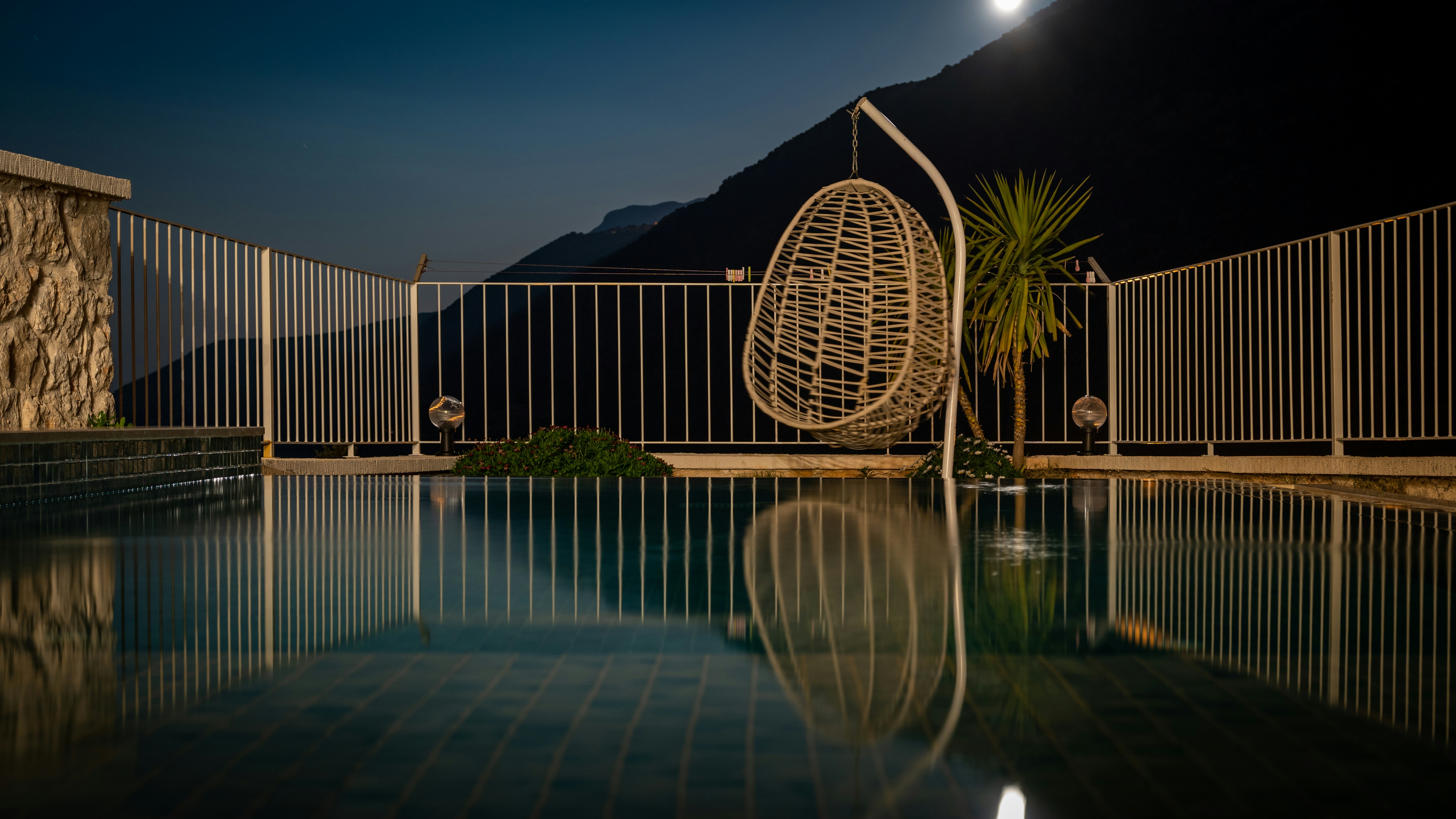 Swinging chair behind the pool at night Follow @isavelev on https://www.instagram.com/isavelev/ for more photos