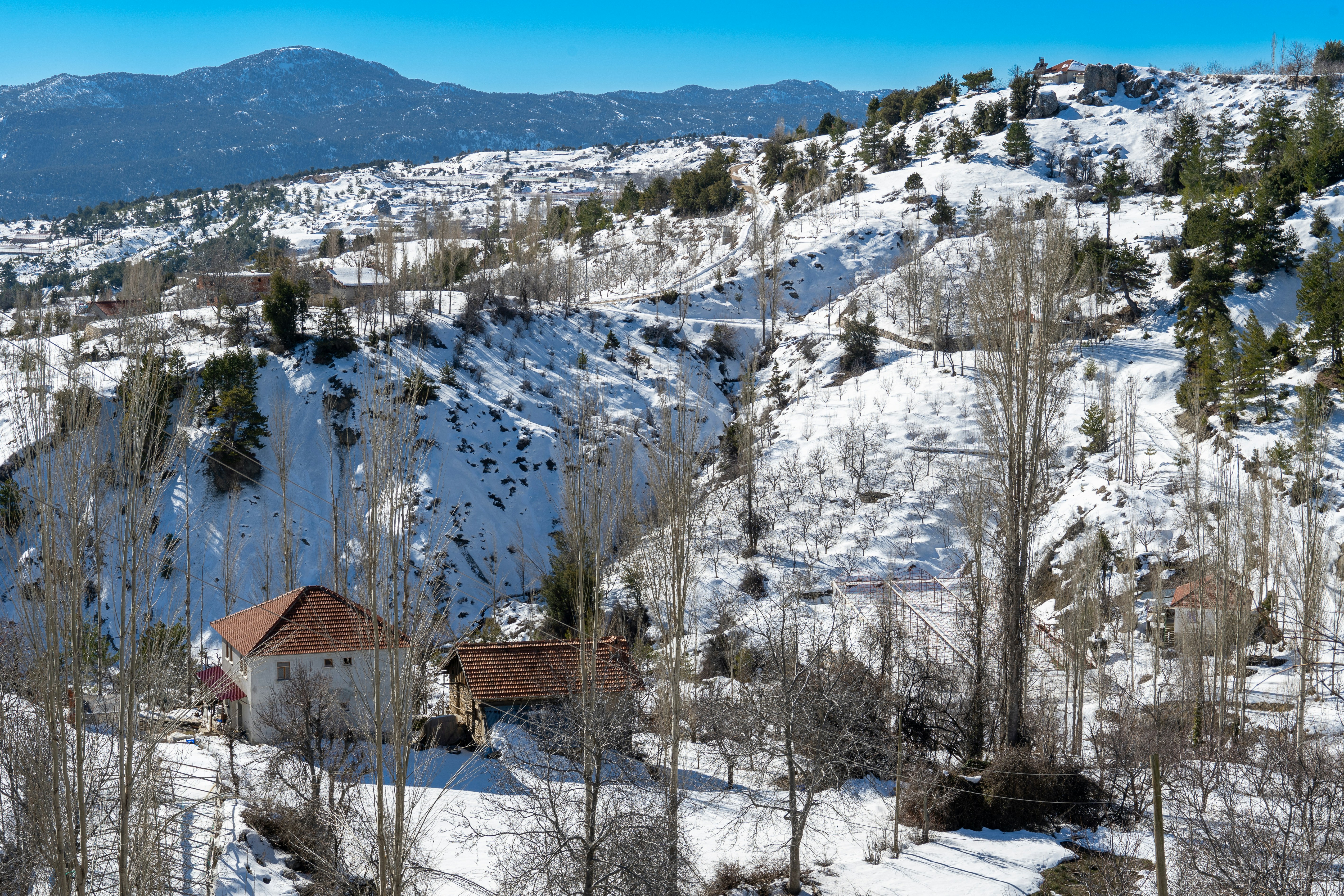 Foto Una montaña cubierta de nieve con una casa en la cima – Imagen ...
