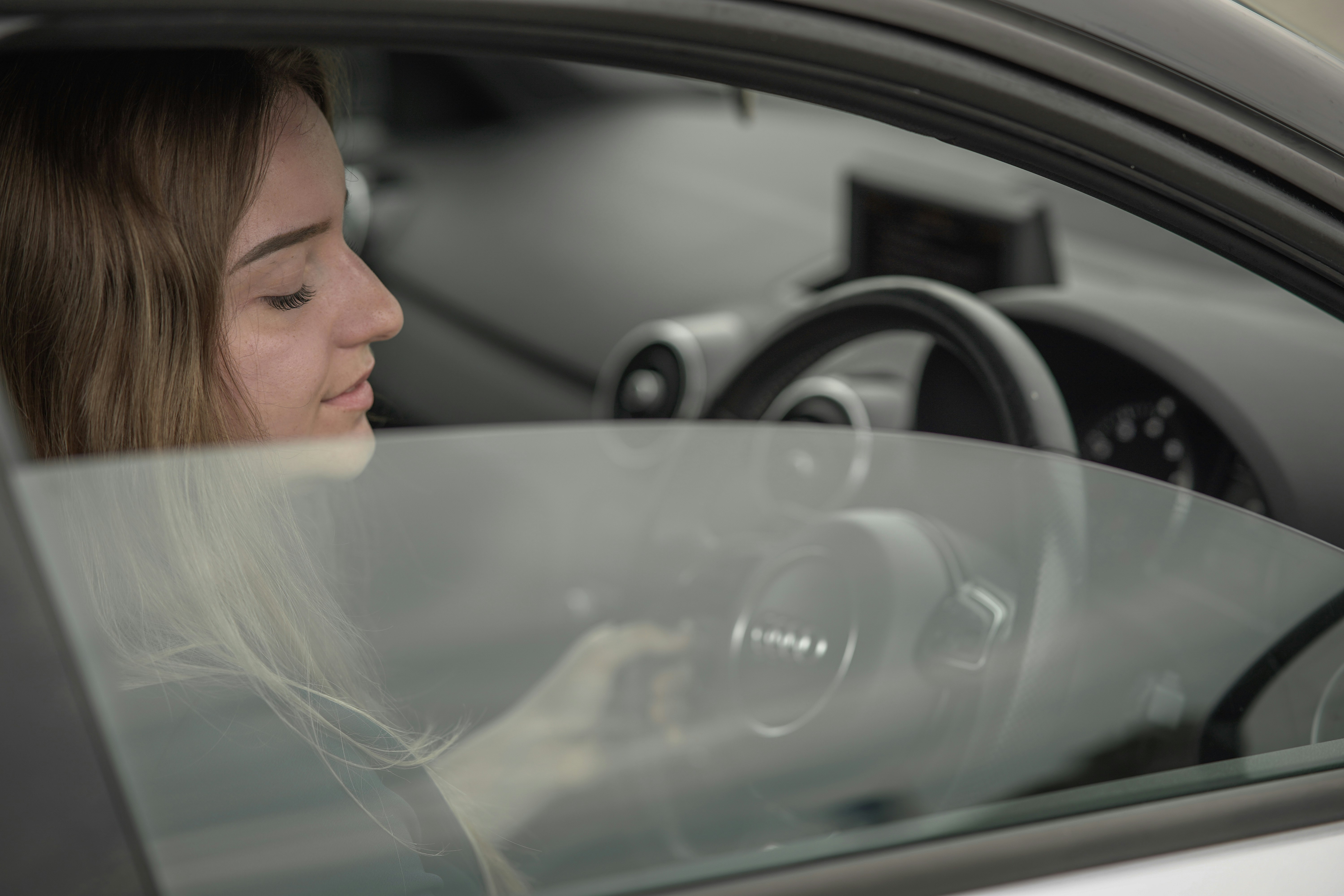 A woman sitting in a car with her head out the window photo – Free ...