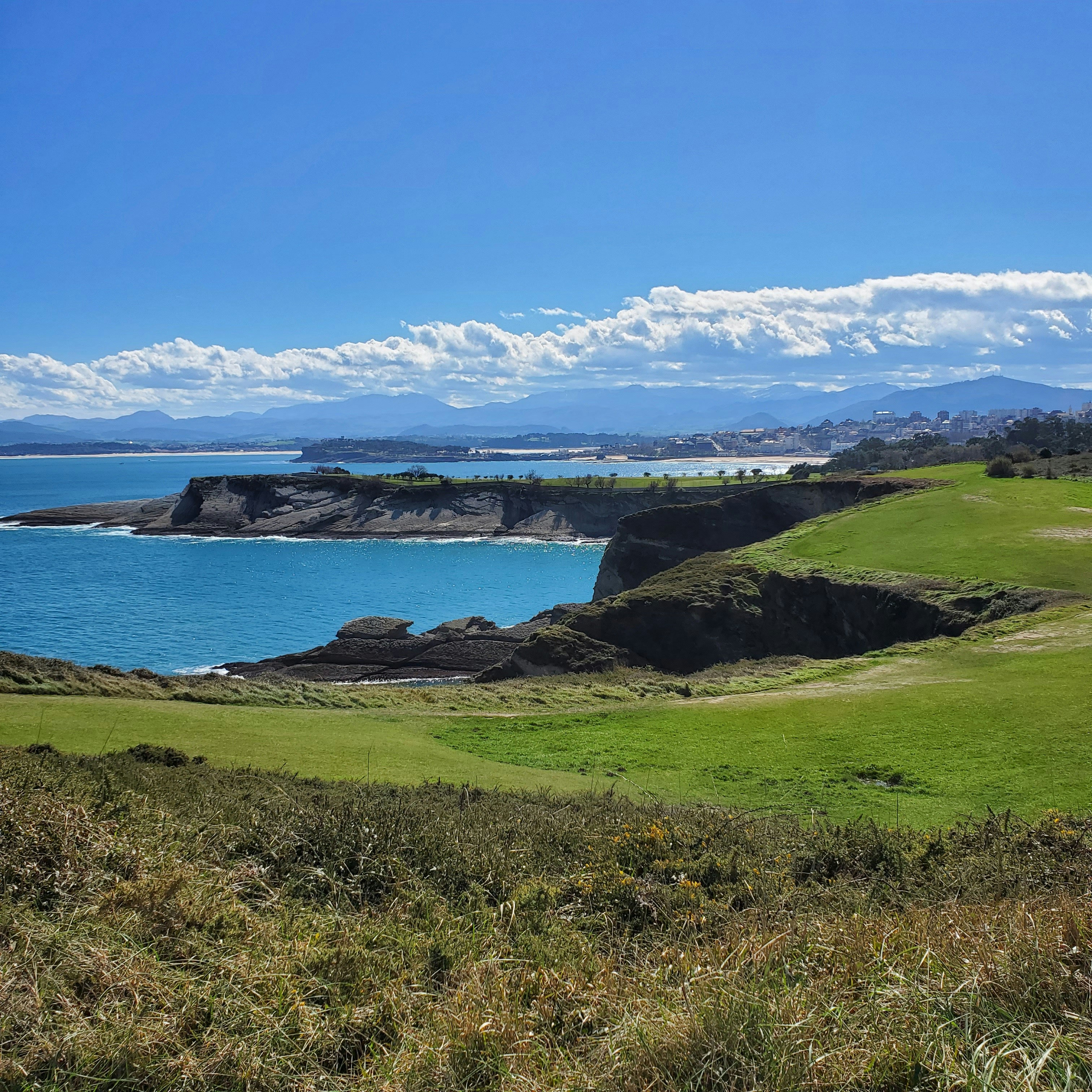 A view of a golf course with a body of water in the background photo ...