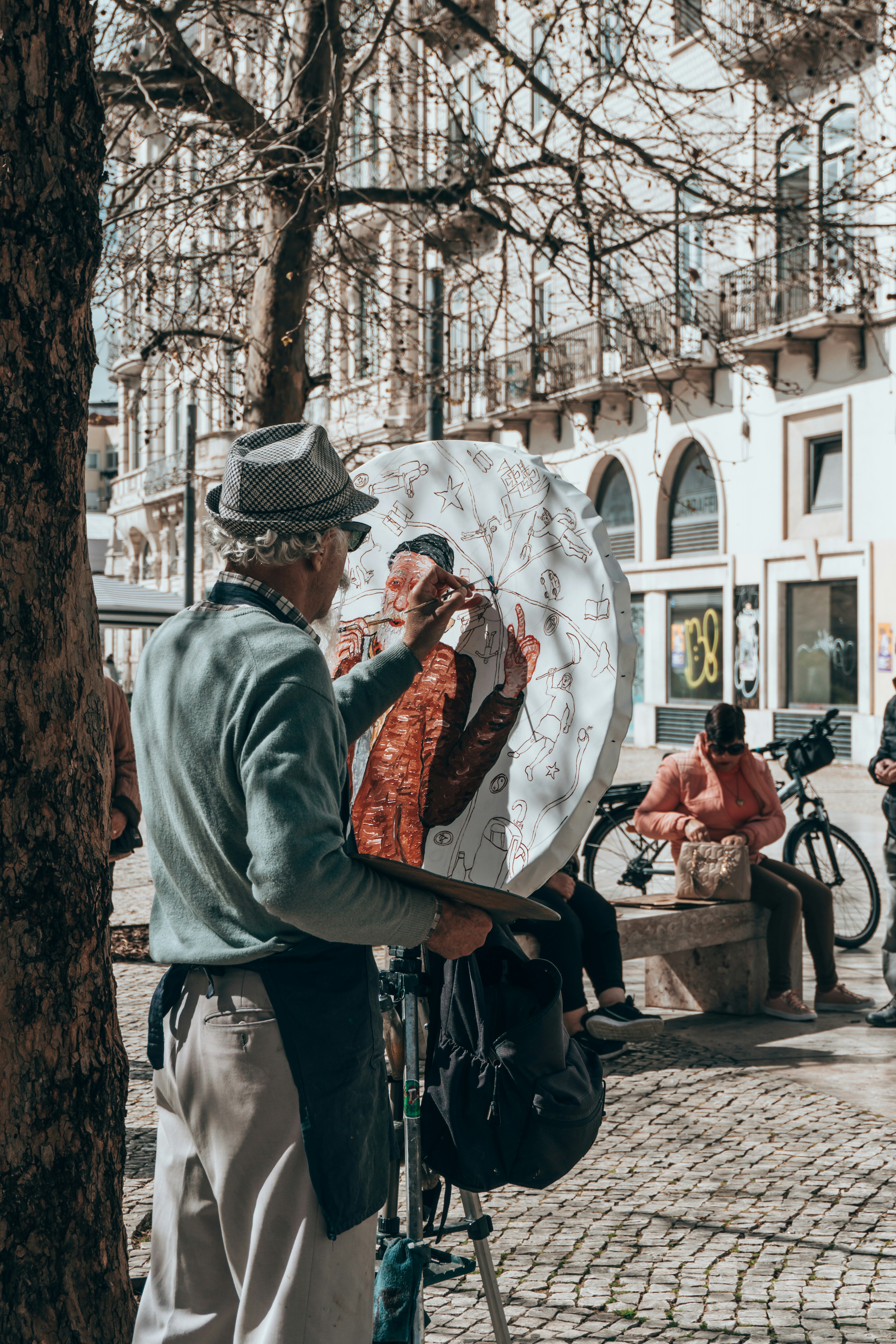 a man standing next to a tree holding an umbrella
