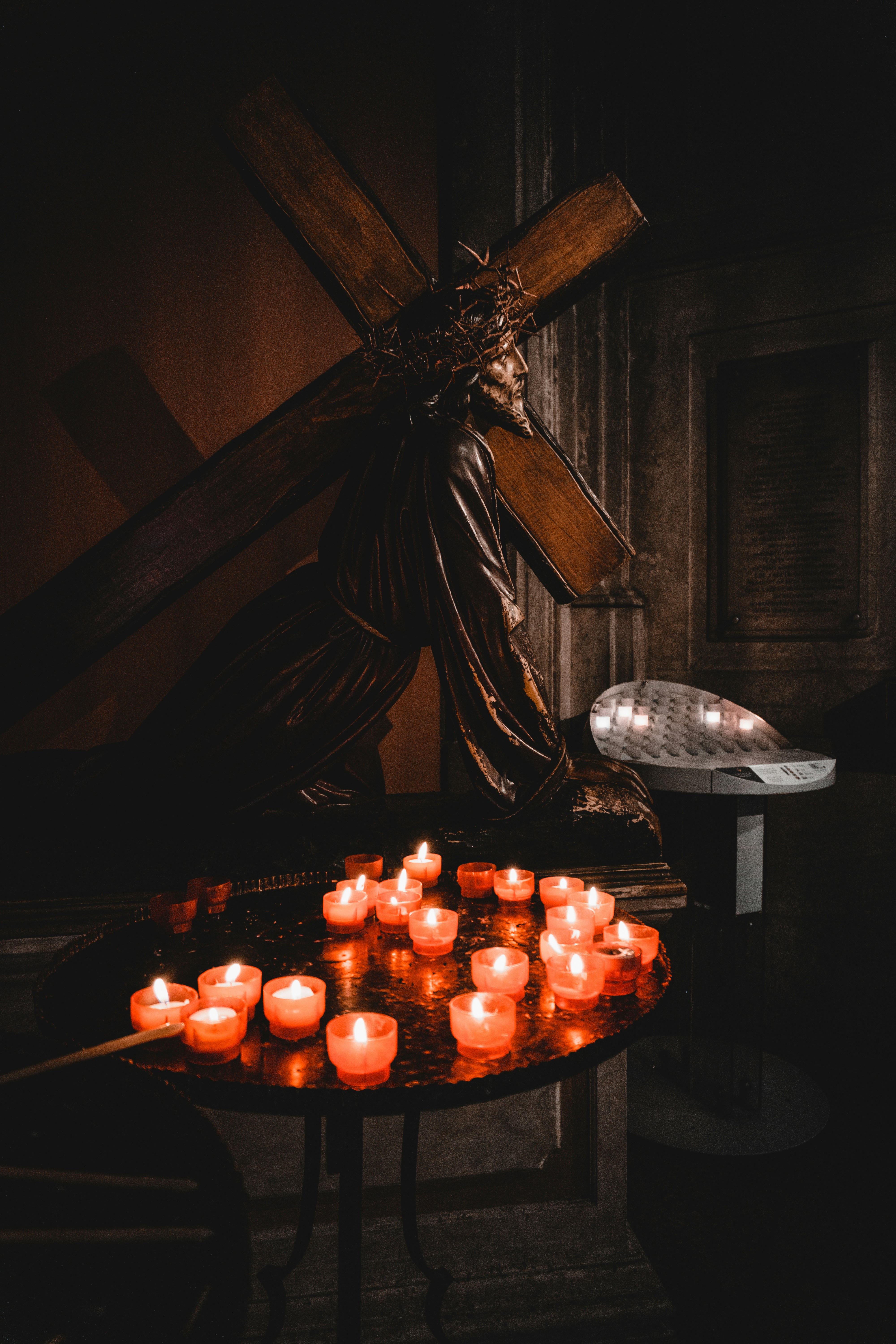 Candlelit Reverence Beneath a Weathered Cross