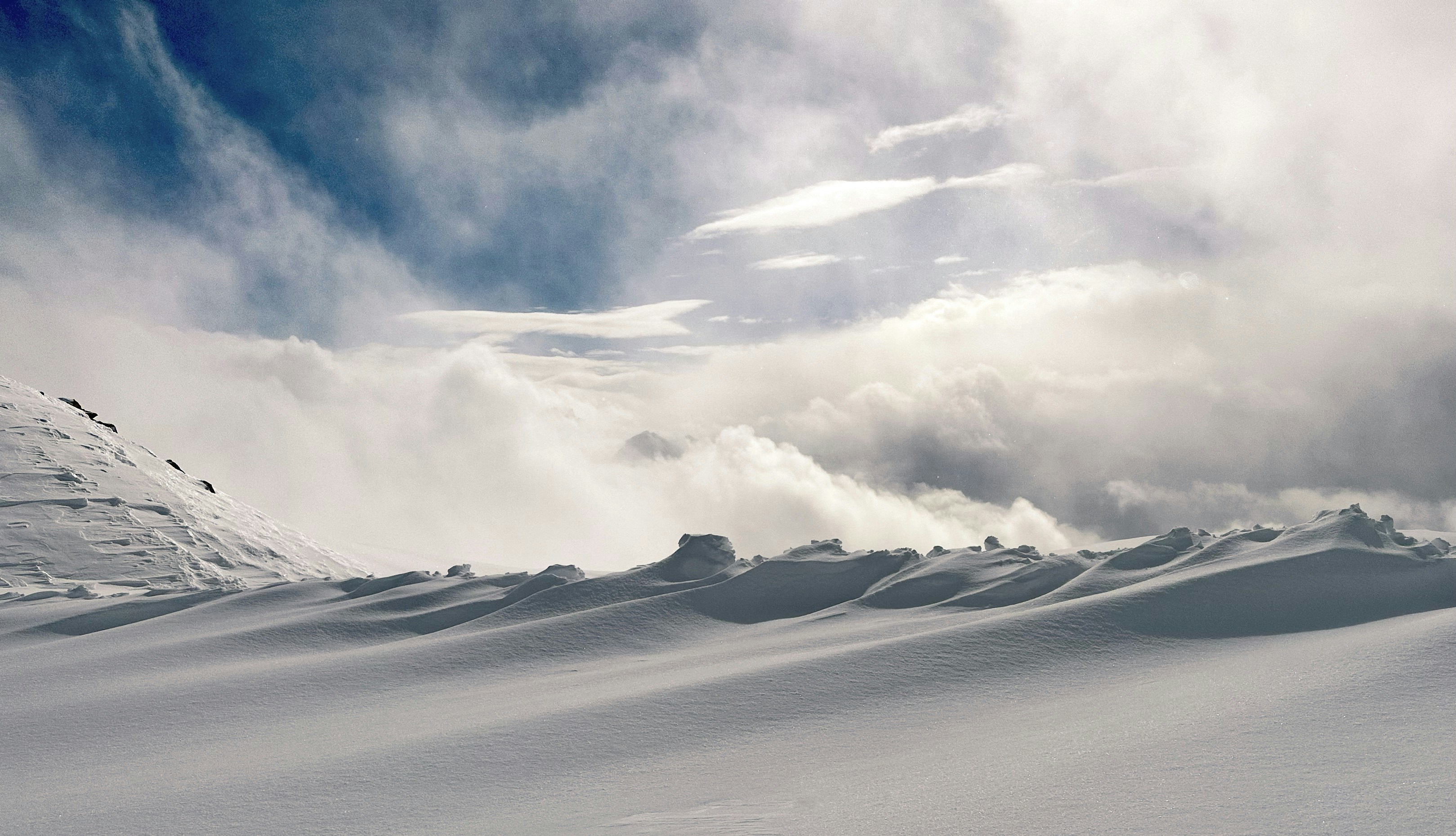 Snow vs clouds | a person riding skis down a snow covered slope