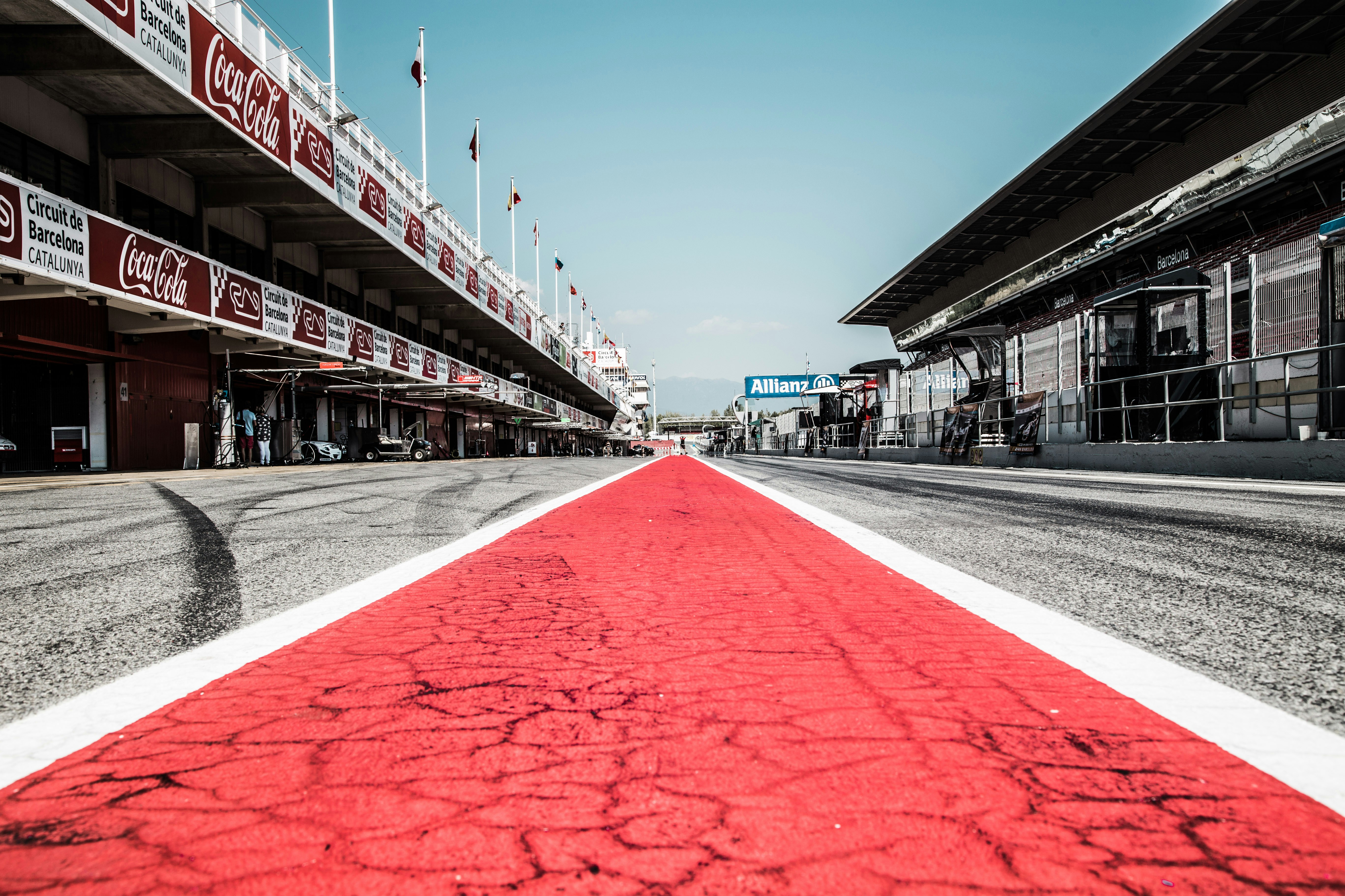 A race track with a red and white line painted on it photo – Free Pit ...