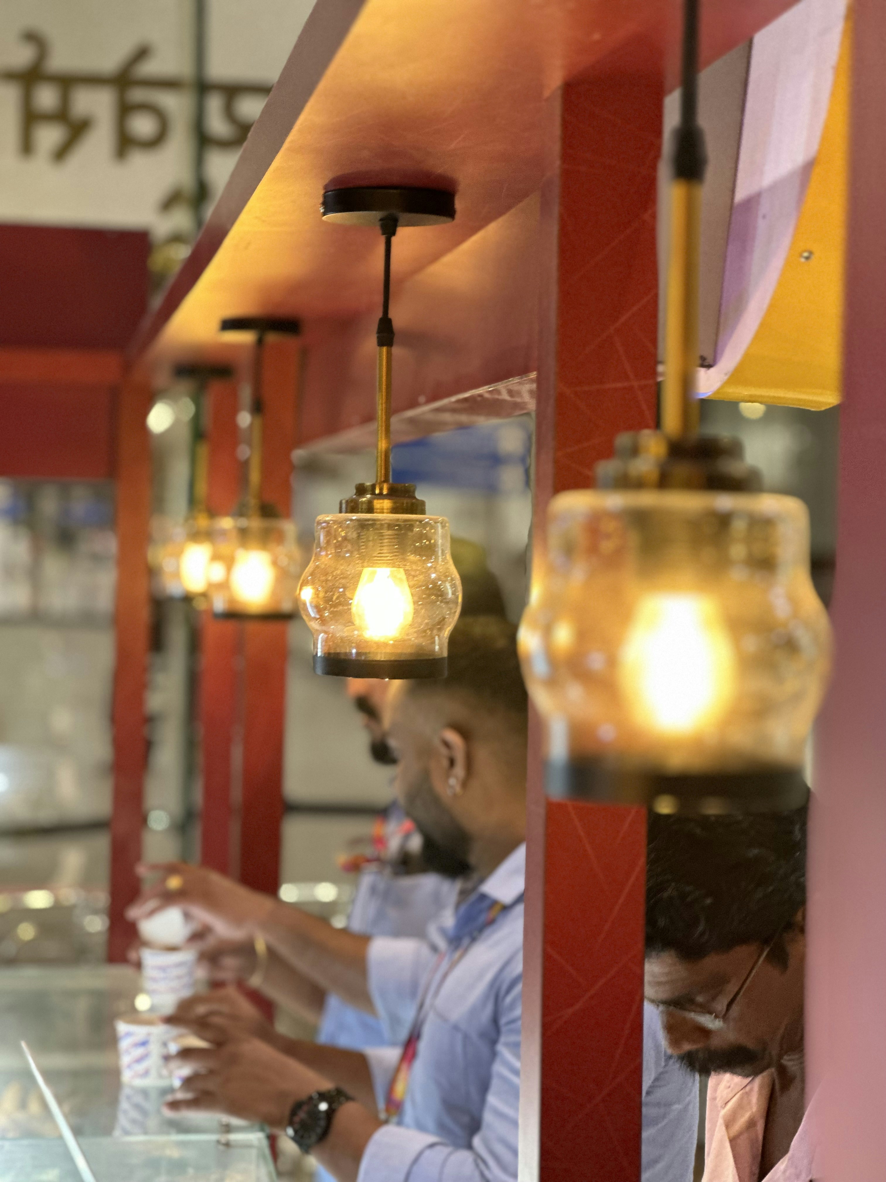 Warm Glow at the Counter: Edison-style Lamps Illuminate a Café Scene