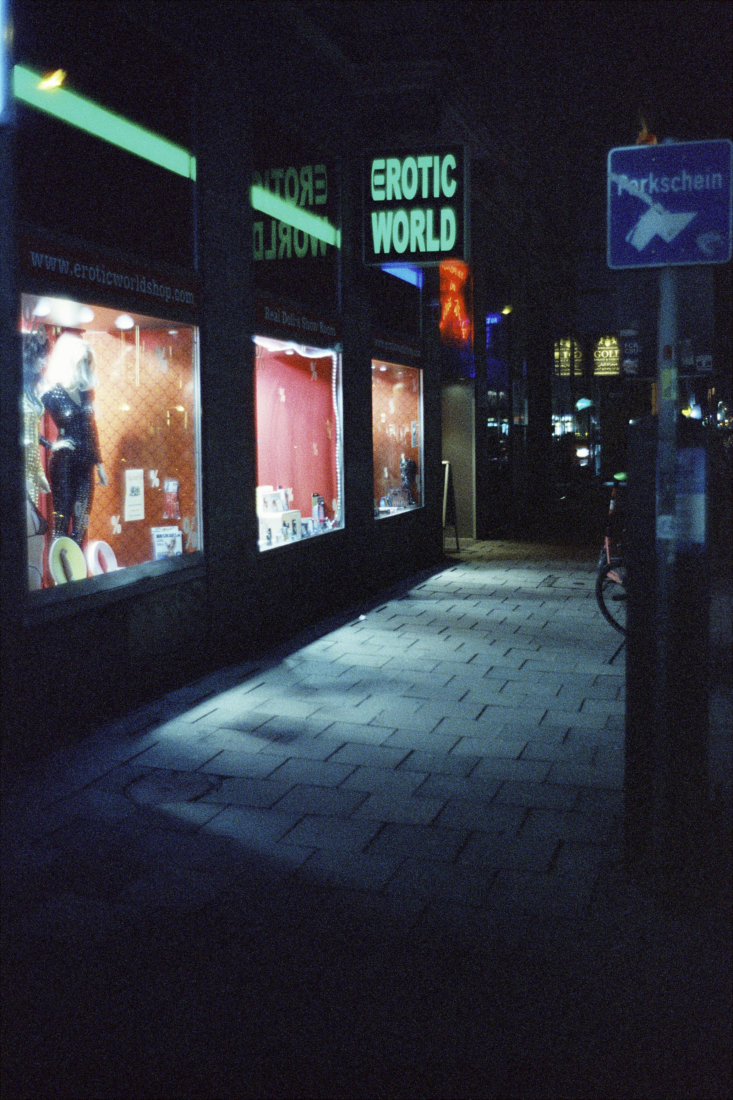 A dark street at night with storefronts lit up photo – Free Urban Image ...