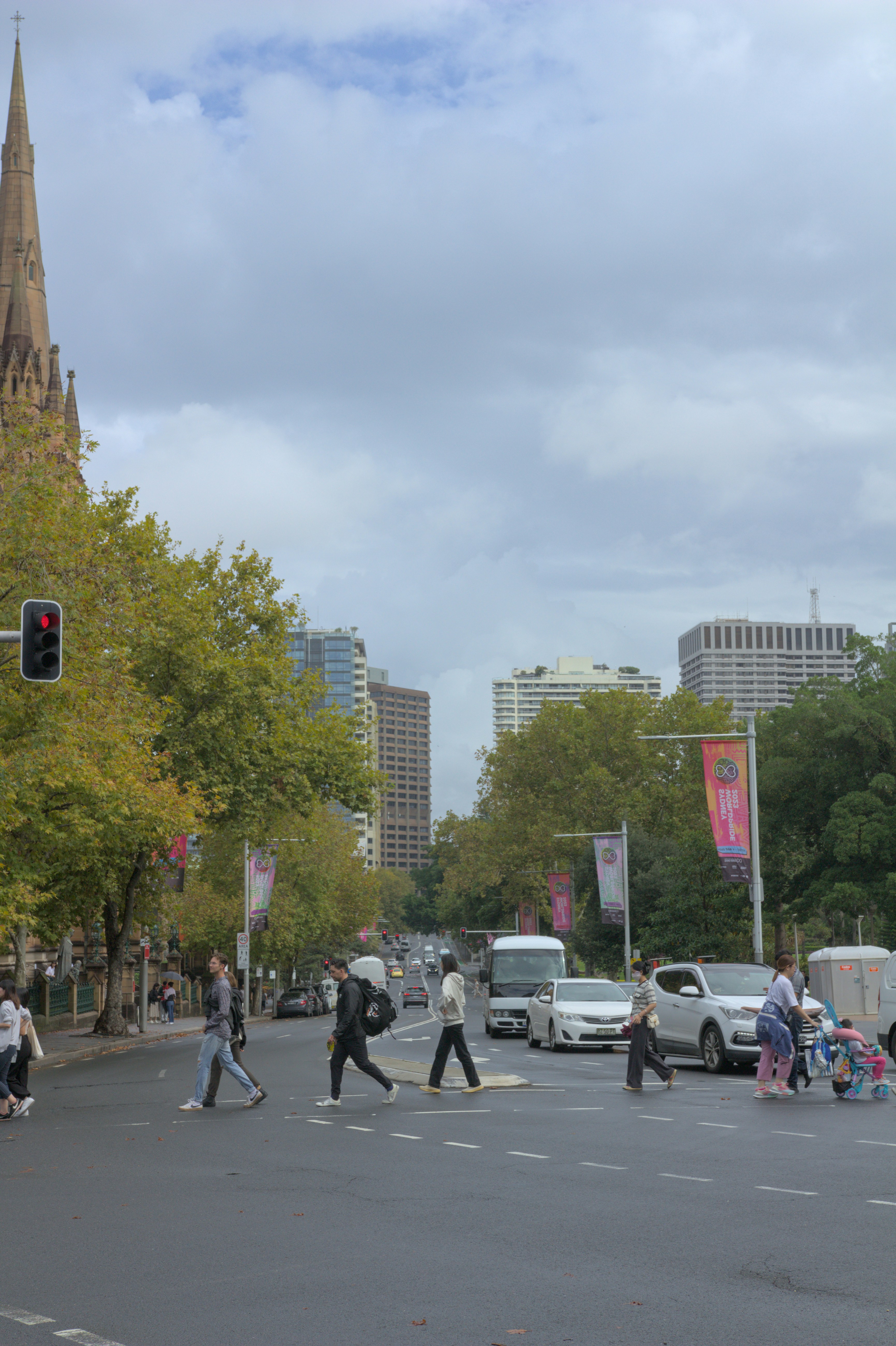 Crosswalk Confluence: Pedestrians Navigate a Tree-Lined City Street