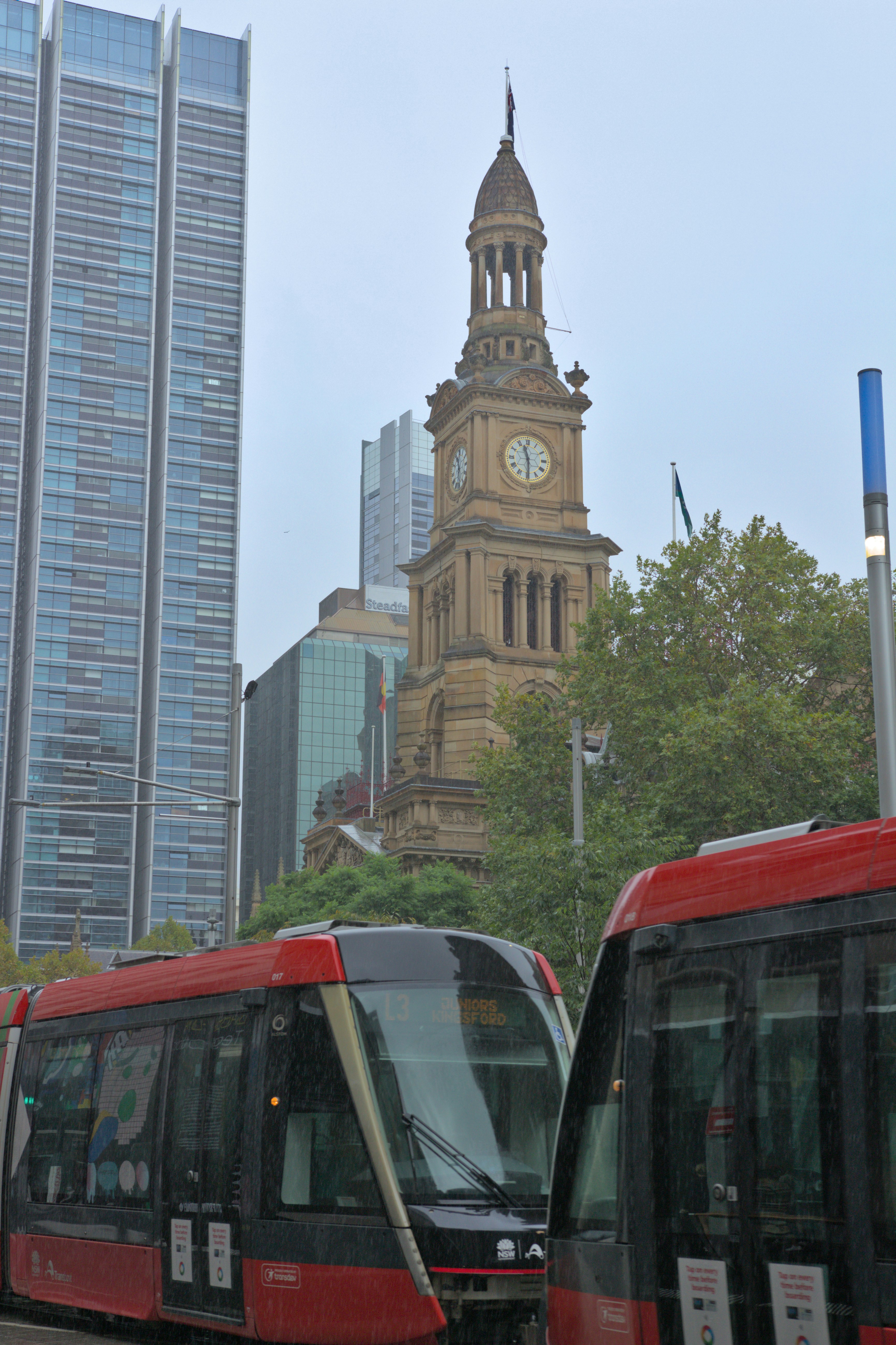 Transit Clockwork: Red Trams Framing a Historic Clock Tower