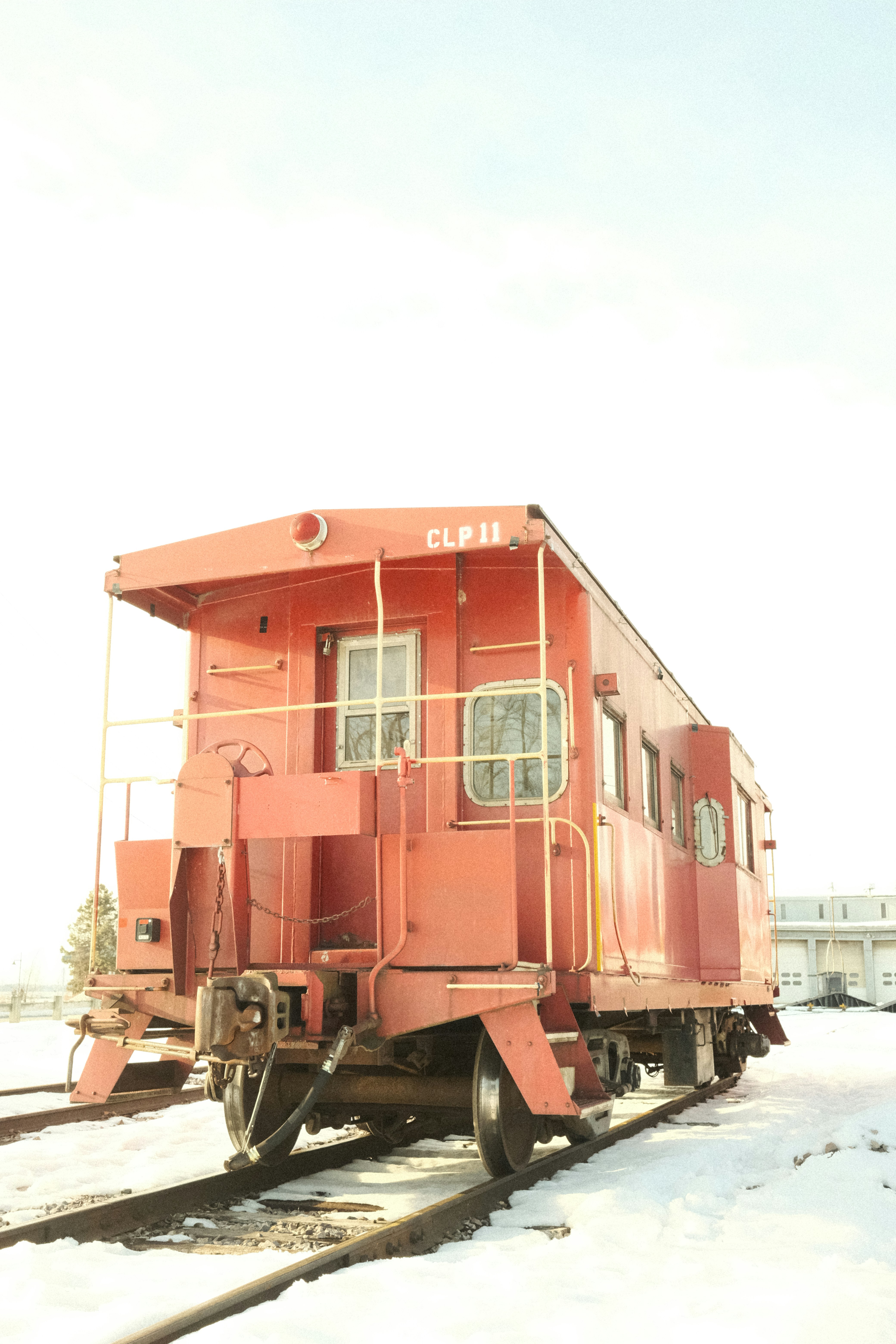 a red caboose sitting on the tracks in the snow