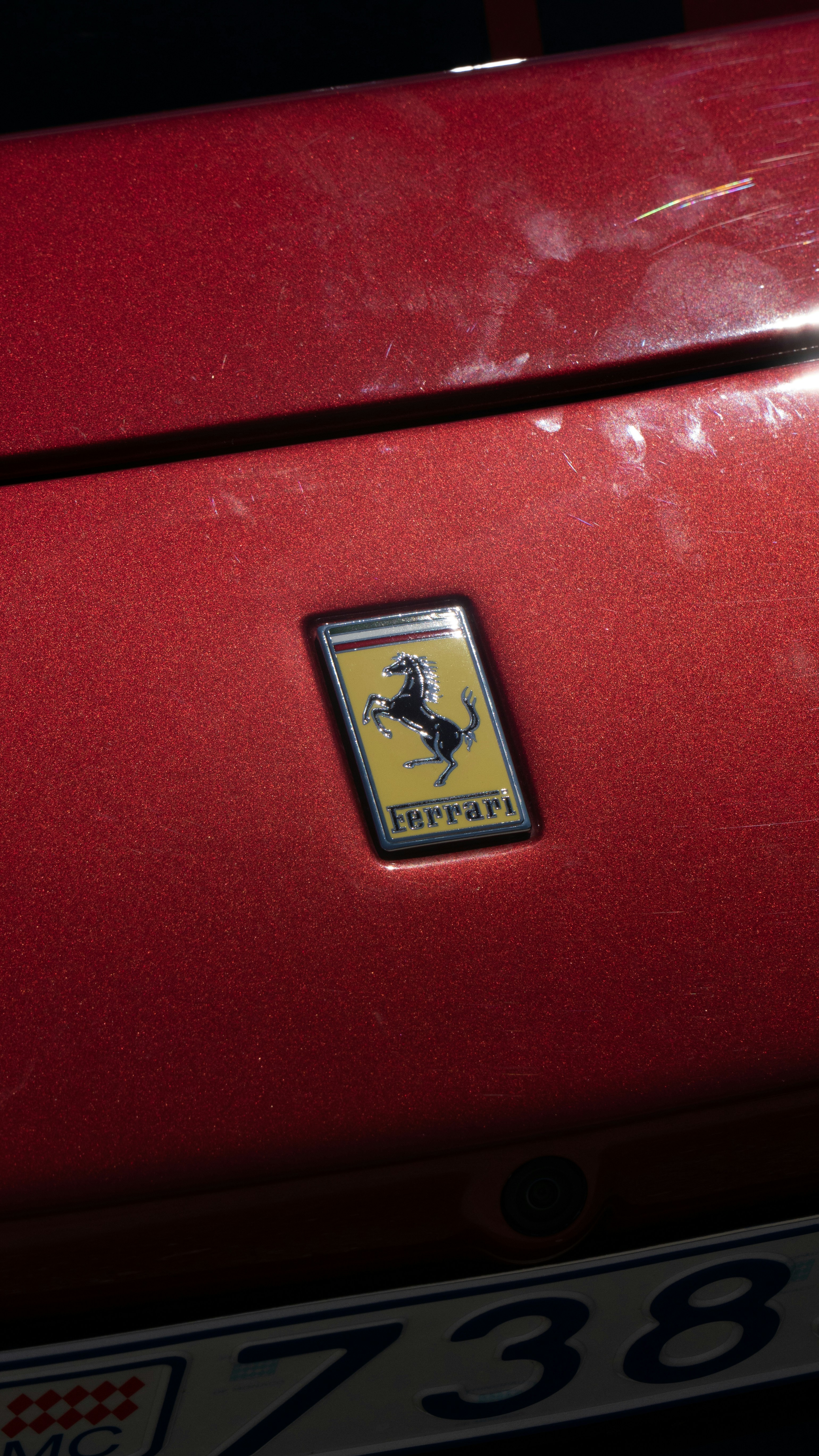 Scarlet Shield in Scratches: Ferrari Emblem on a Glossy Red Surface