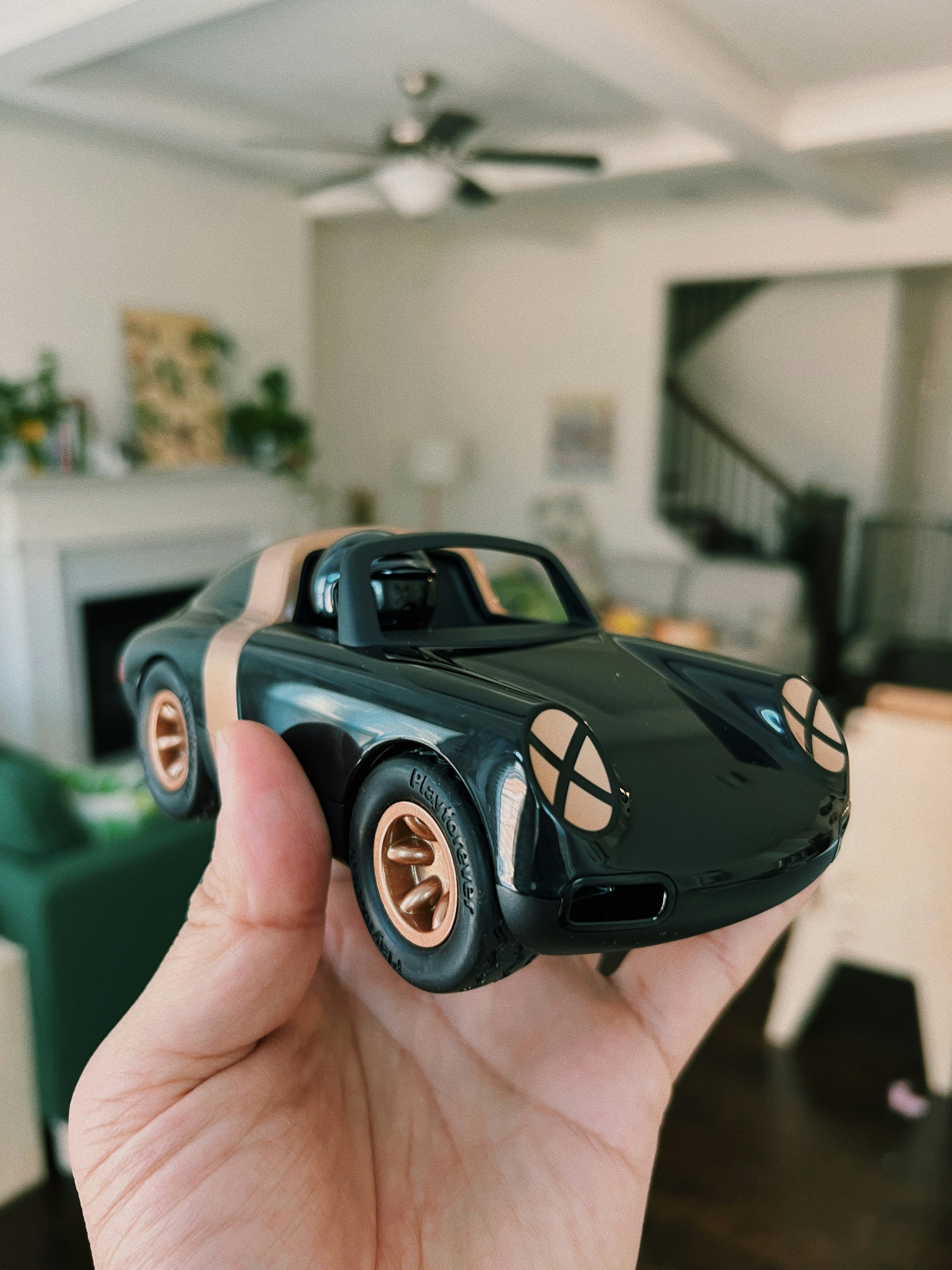 a person holding a toy car in their hand