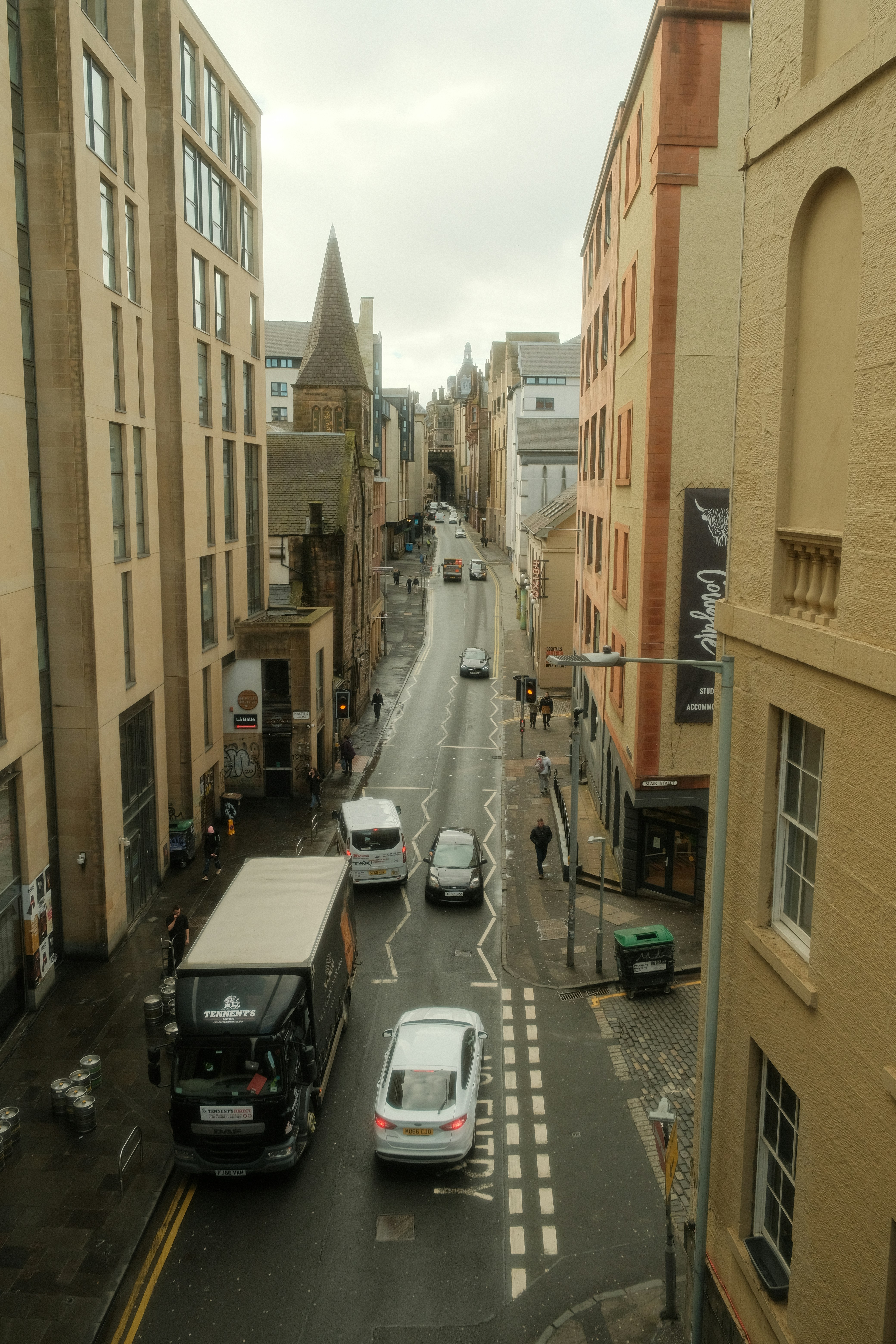 a city street filled with traffic next to tall buildings