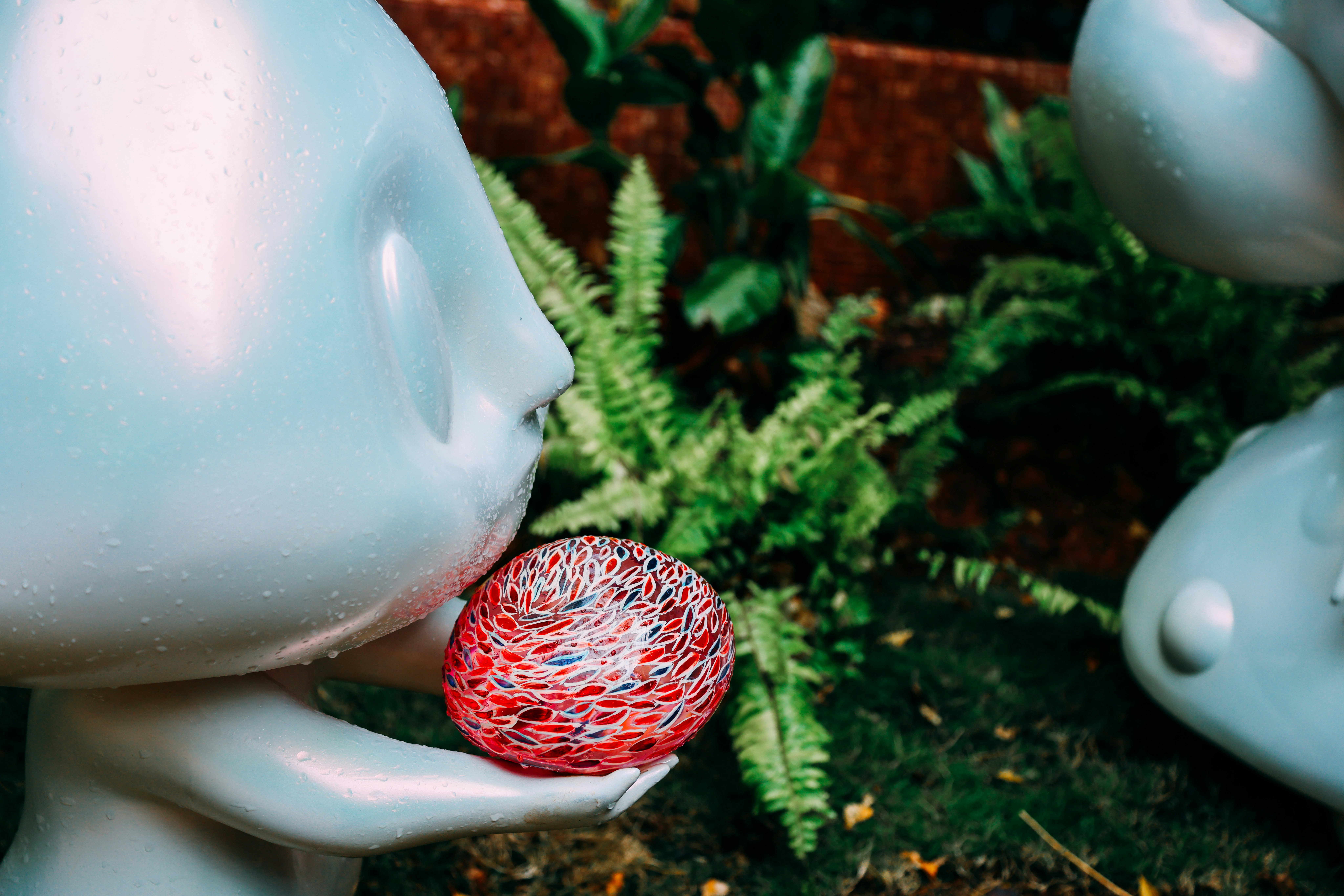 Tender Exchange: A Pale Sculpted Hand Presents a Red Orb