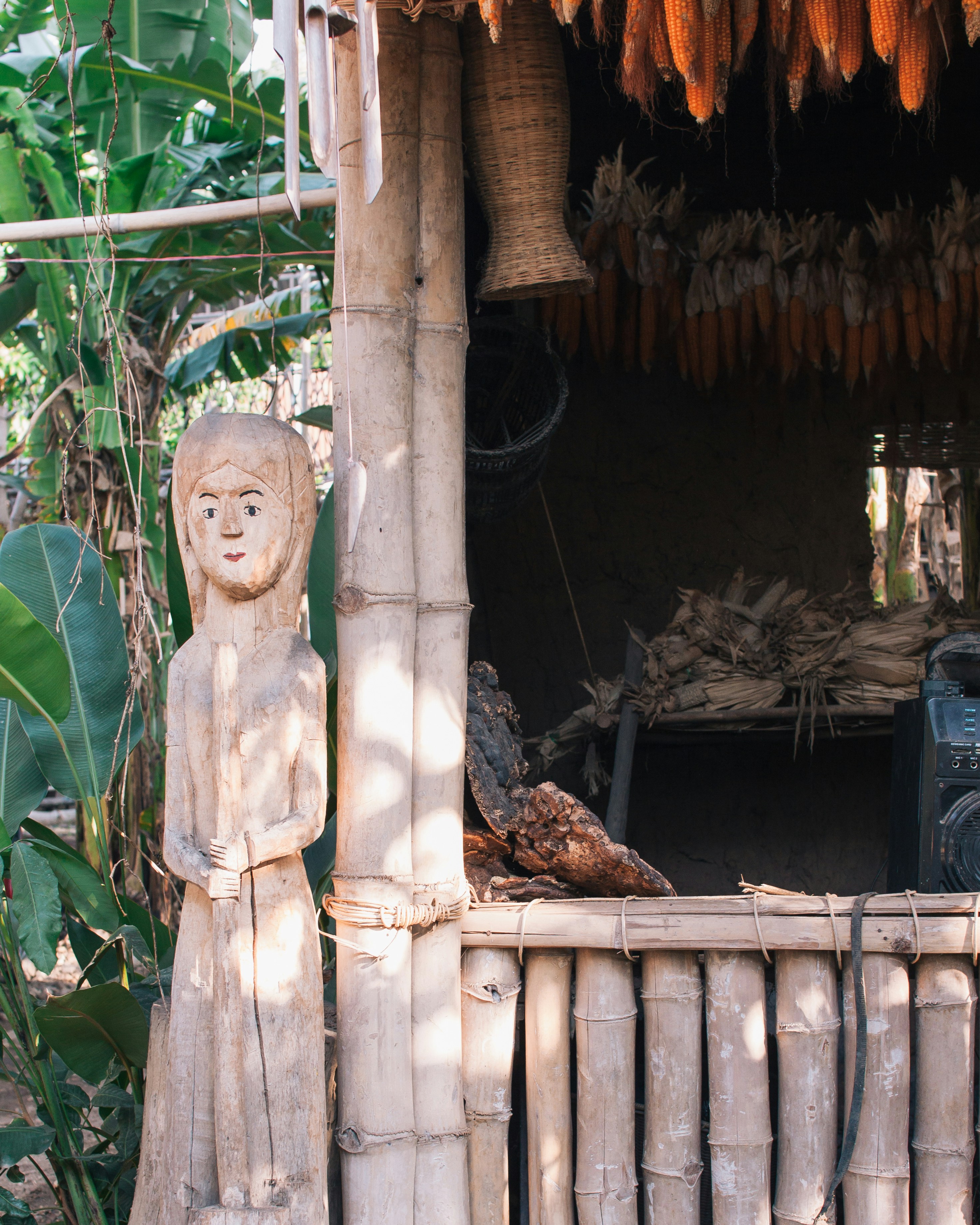 A wooden statue of a person in front of a hut photo – Free Kontum Image ...