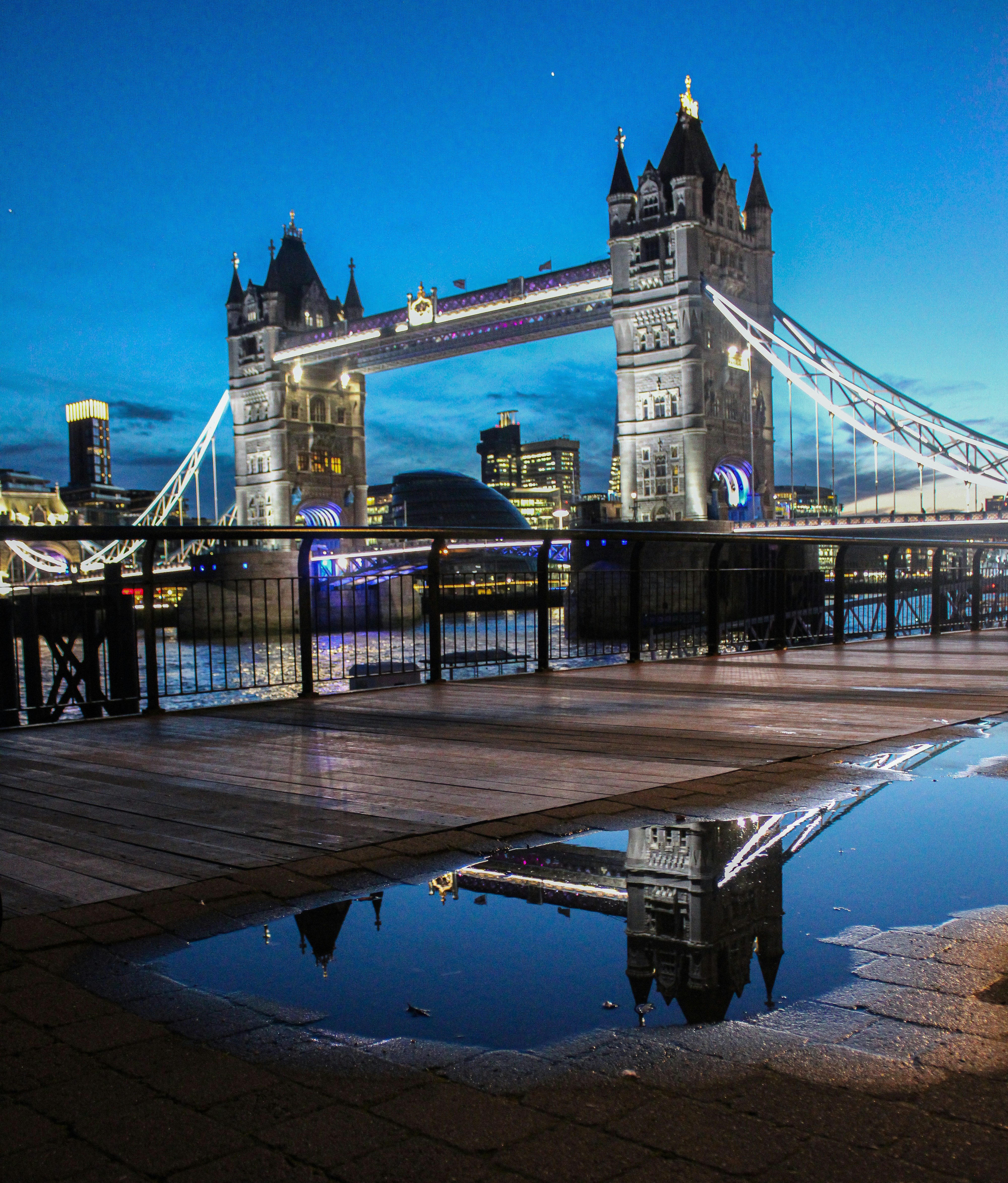A reflection of the tower bridge in a puddle of water photo – Free ...