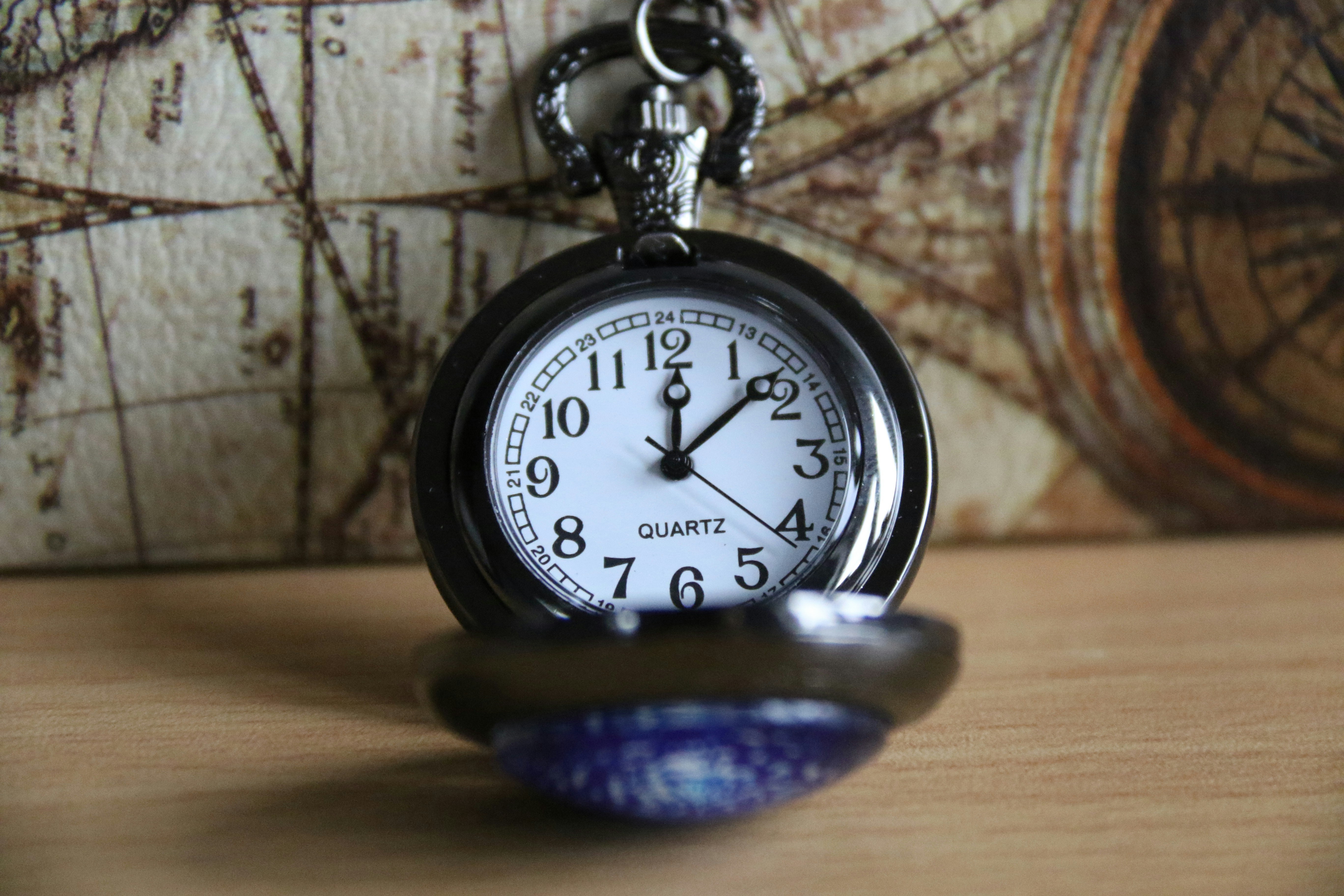 Timekeeper on a Wooden Stage: Pocket Watch Before a Vintage Map