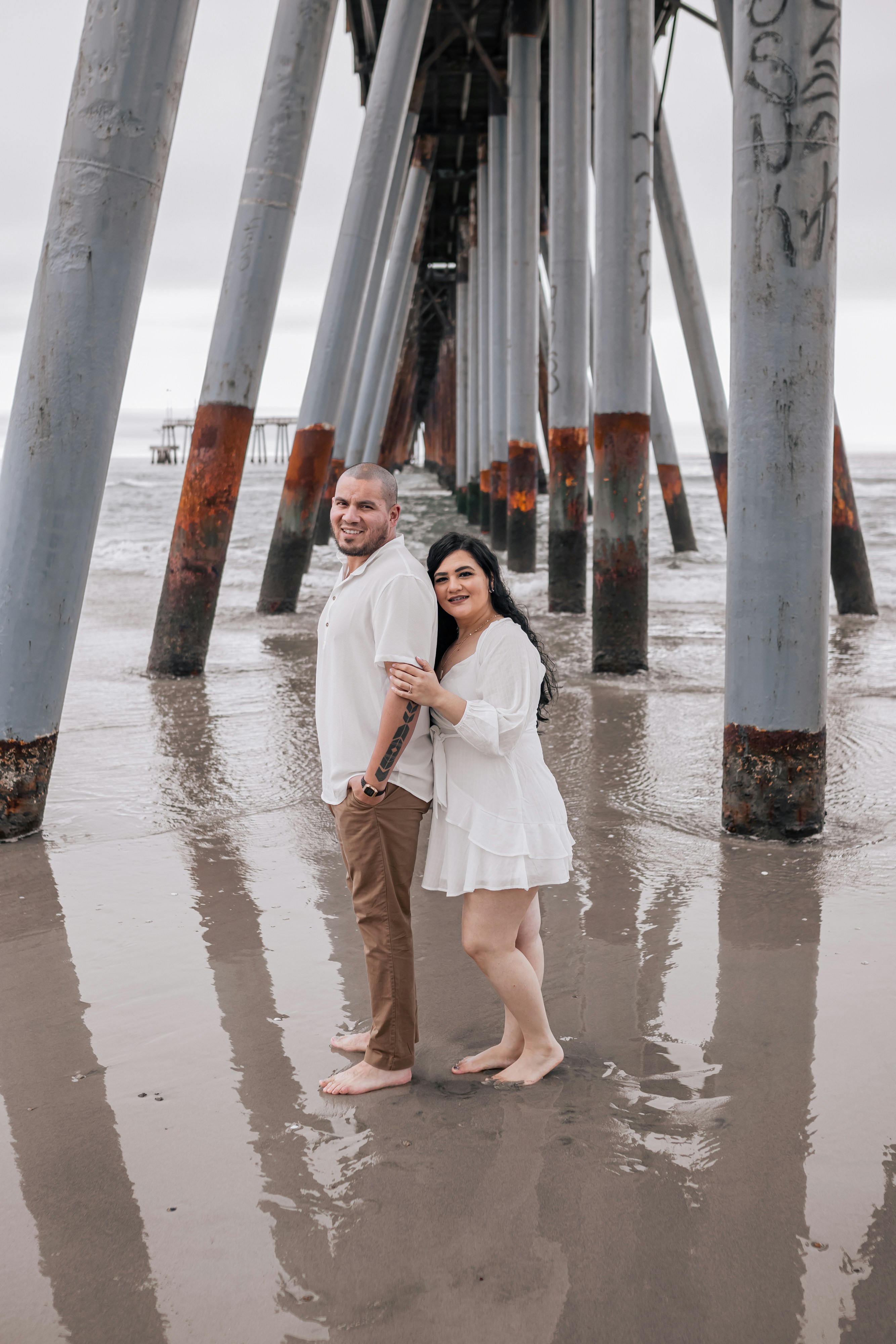 A man and a woman standing under a pier photo – Free Waterfront Image ...