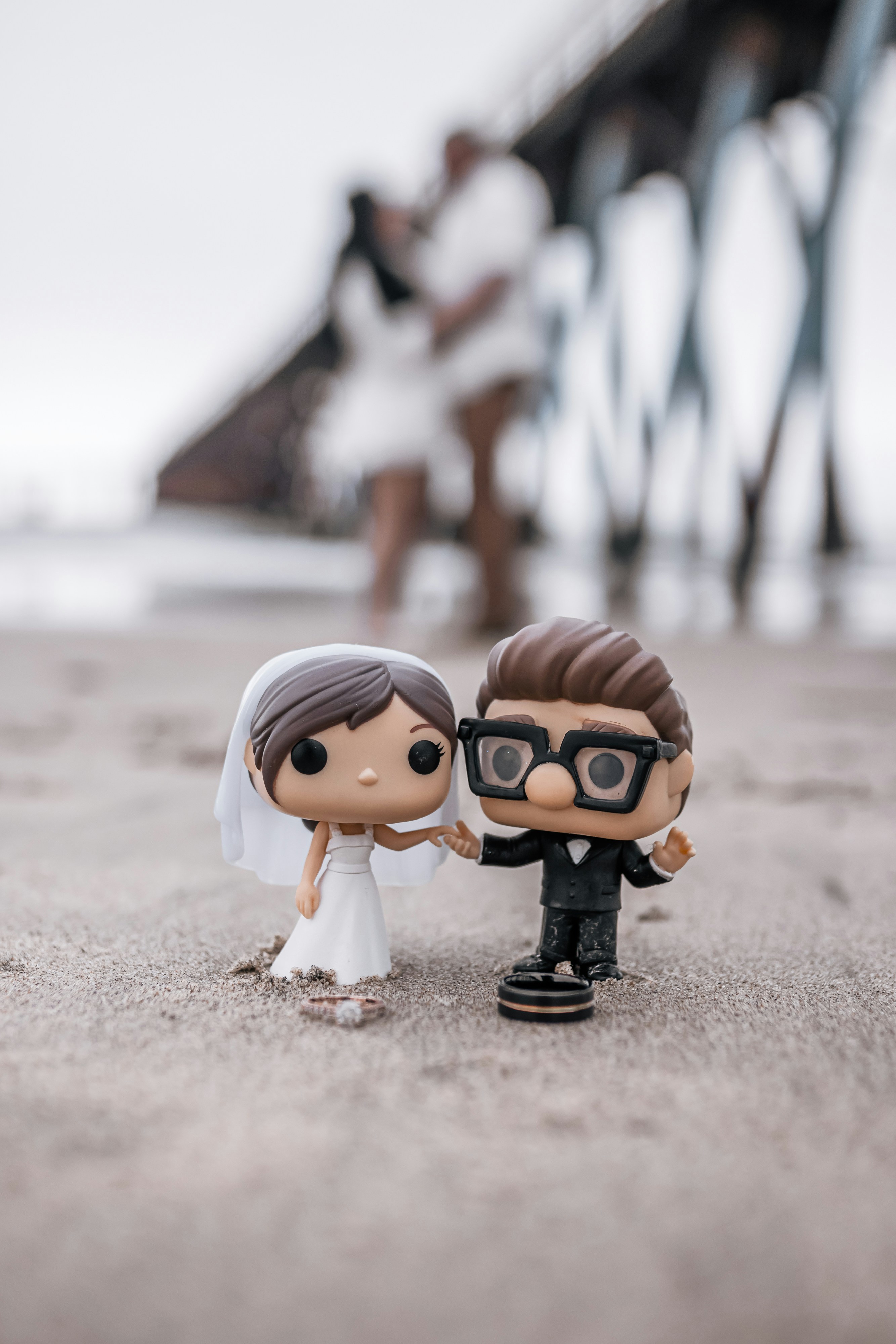 a bride and groom holding hands on the beach