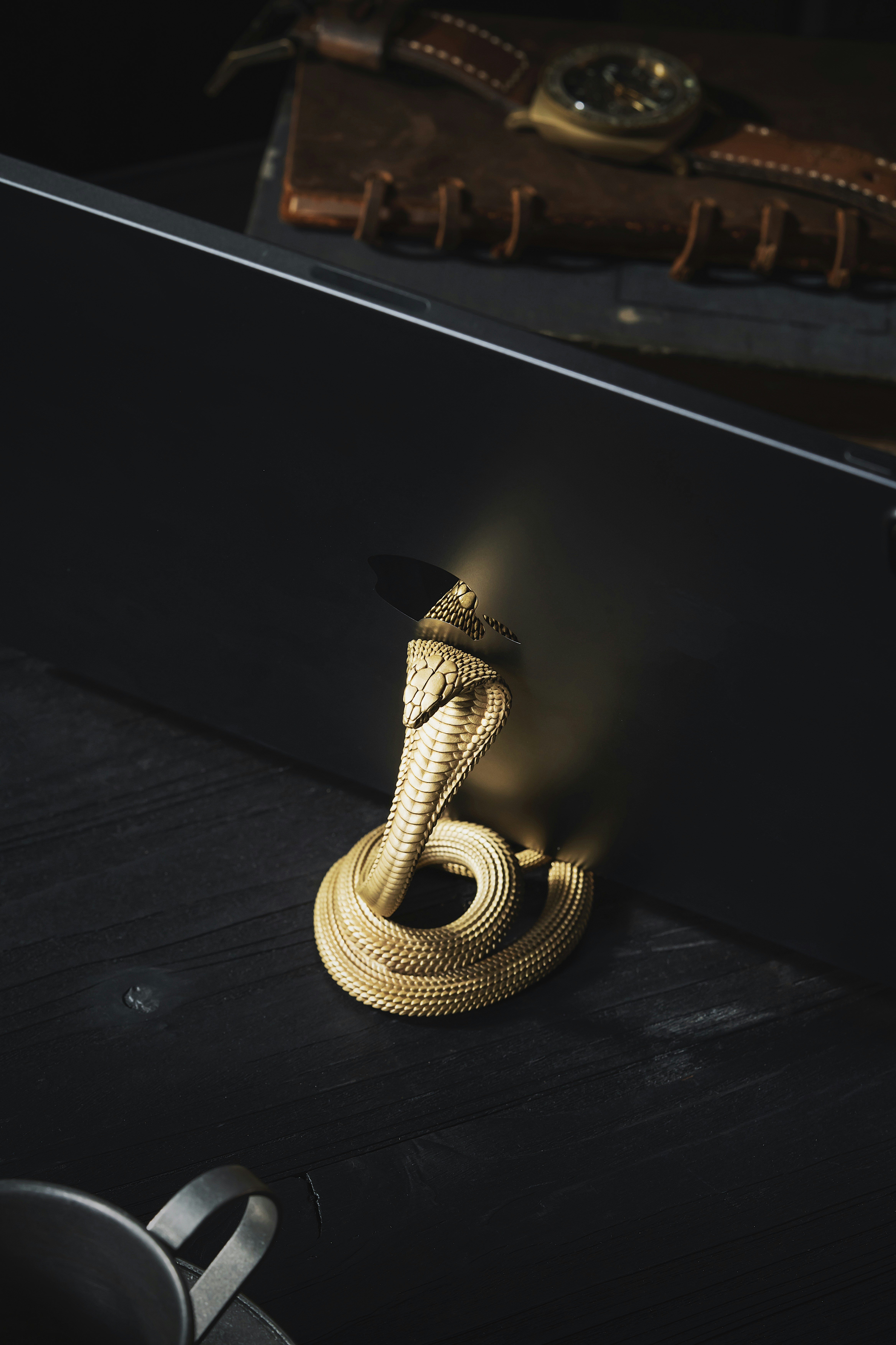 Coiled Guardian: A Golden Cobra Emerging from the Desk