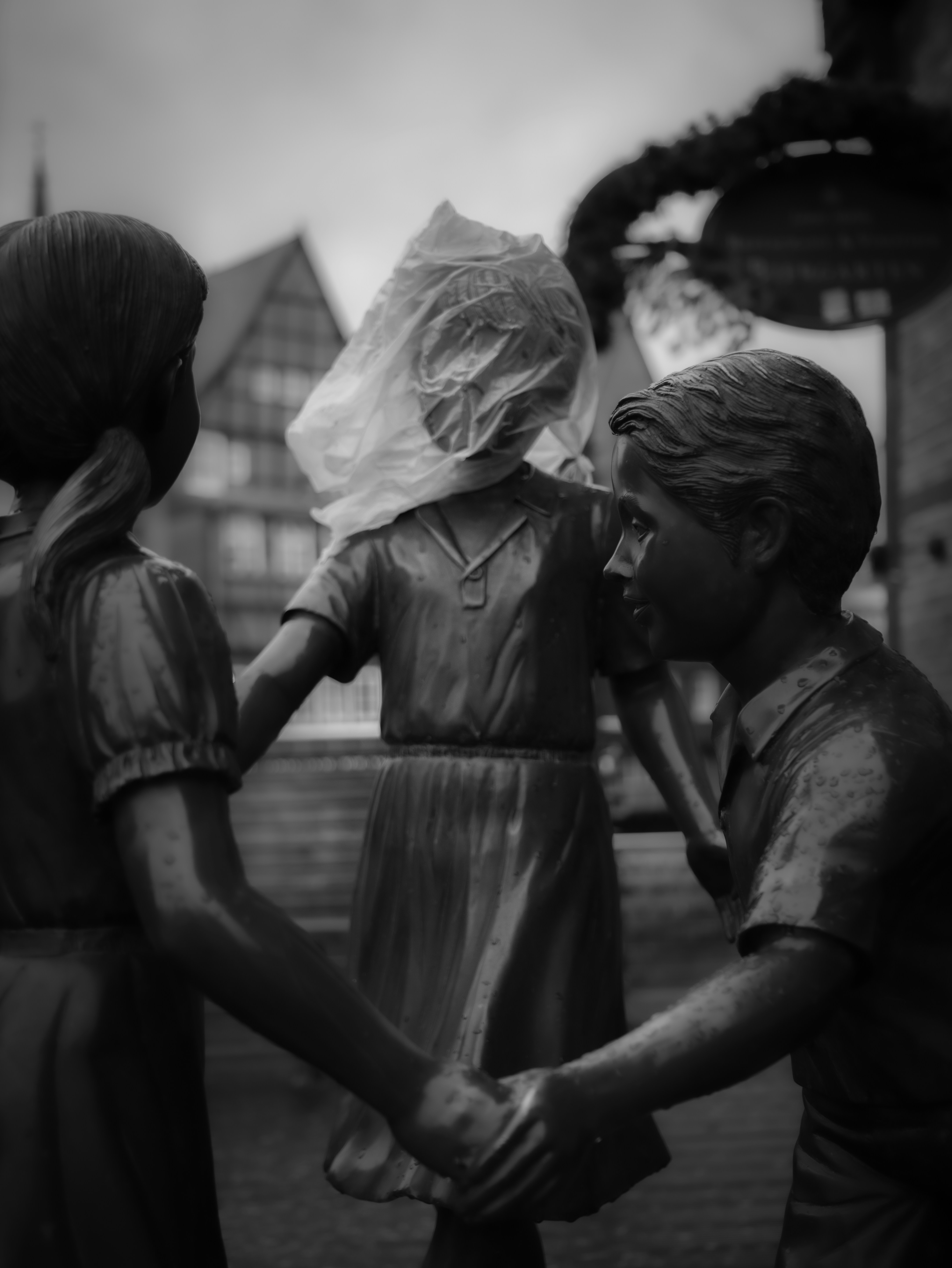 a black and white photo of three children holding hands