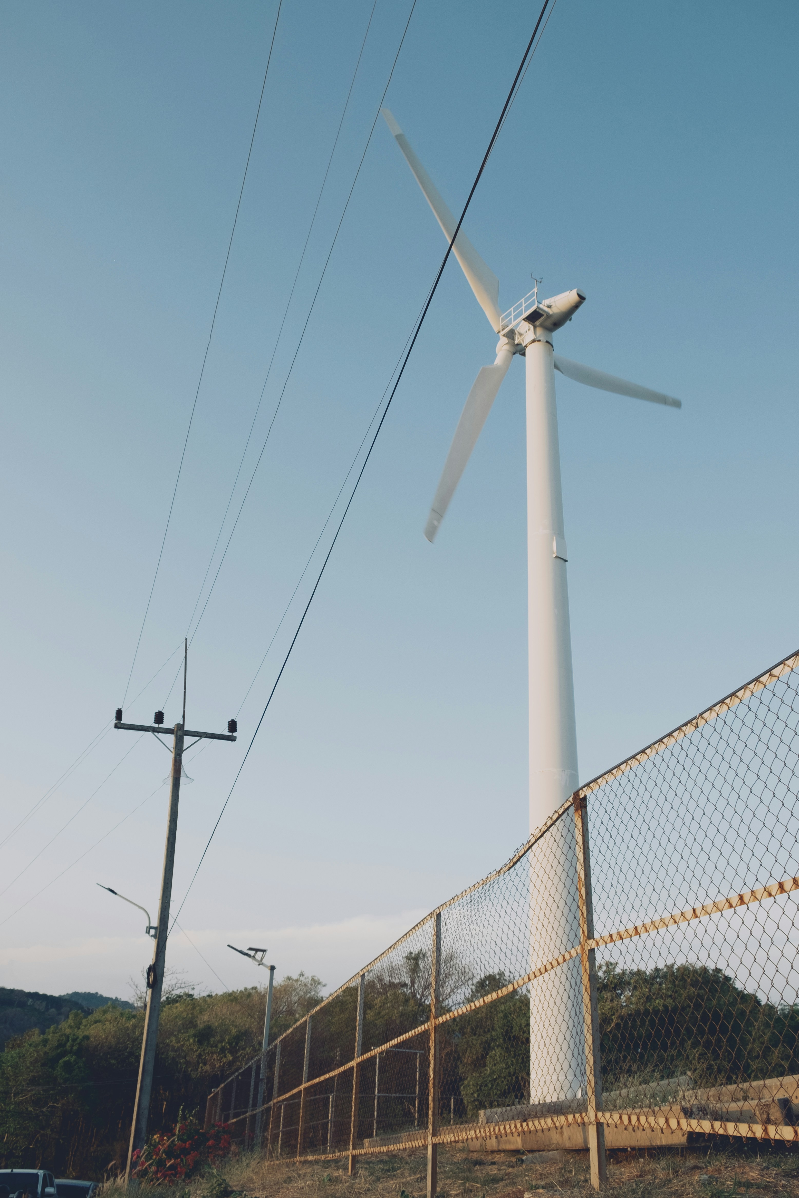 A large wind turbine next to a fence photo – Free Energy Image on Unsplash