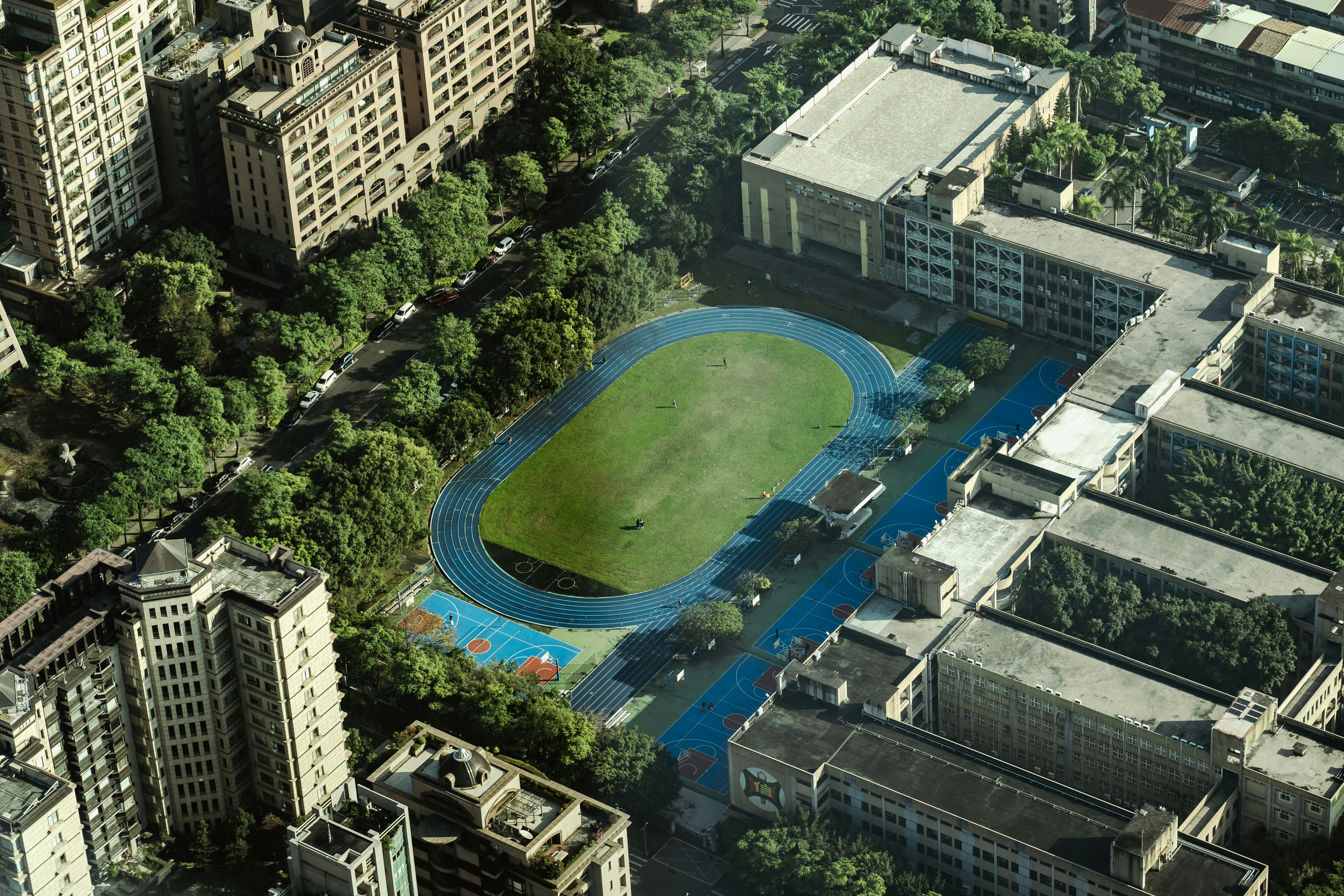 An aerial shot of an athletics track in Taipei, Taiwan | an aerial view of a park in a city