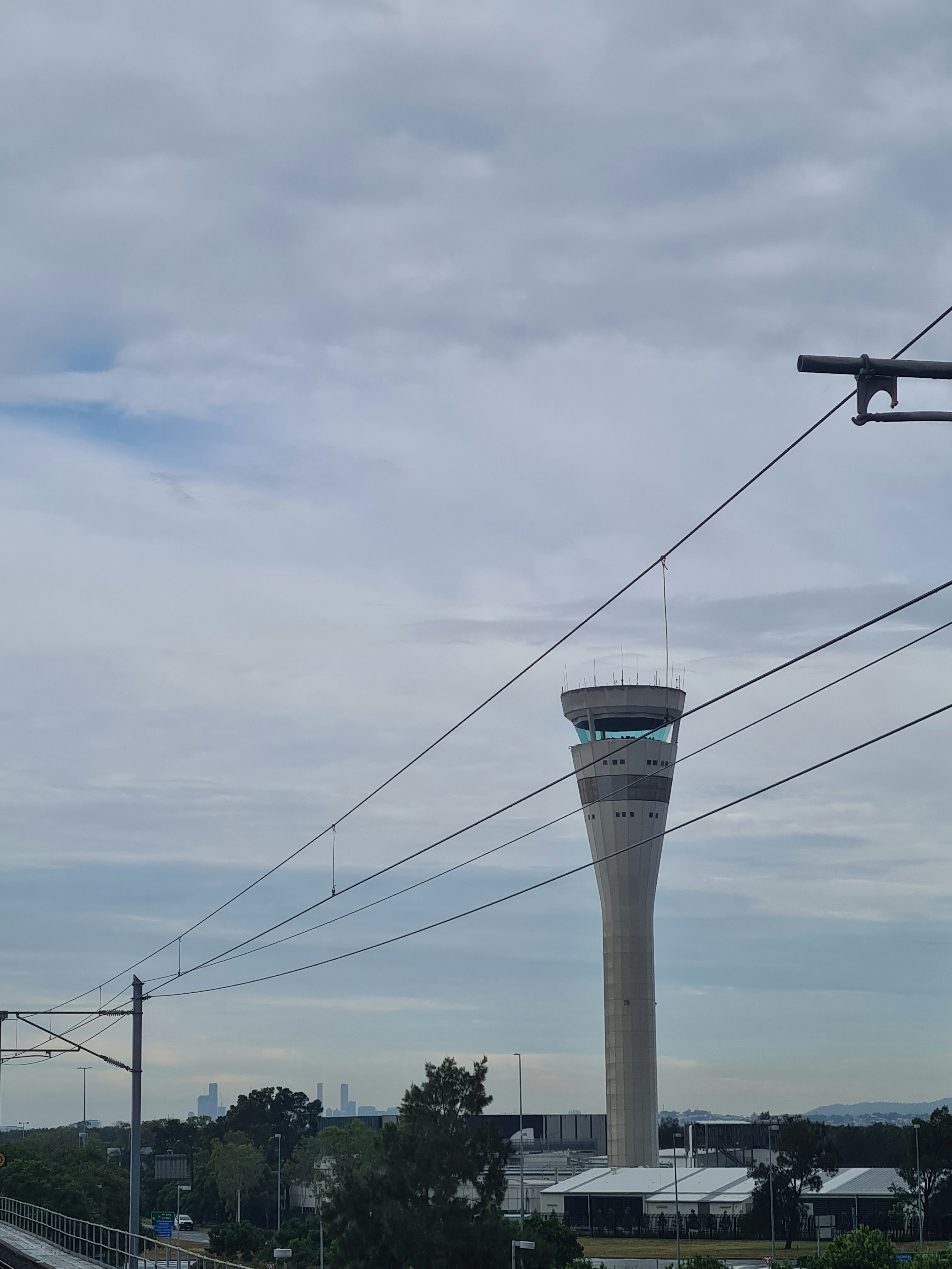 a tall tower with a control tower in the background