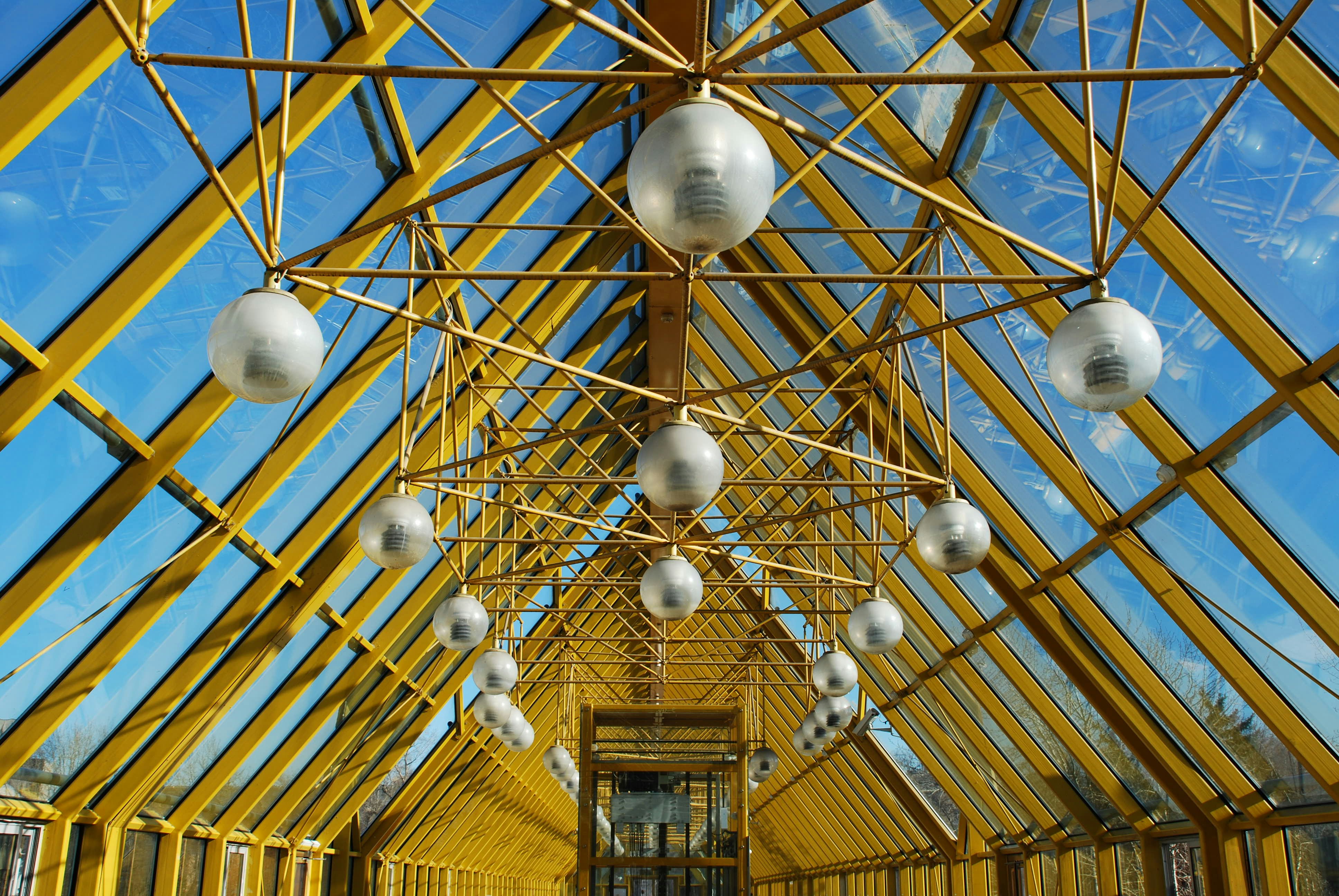a building with a glass roof and a bunch of white balls hanging from the ceiling
