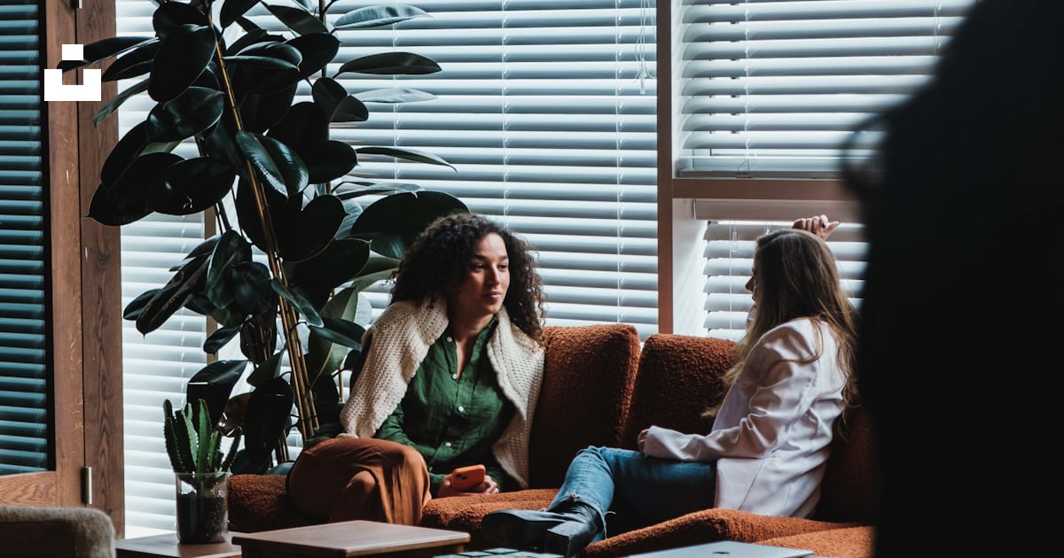 Deux Femmes Assises Sur Un Canapé Dans Un Salon Photo Image Gratuite